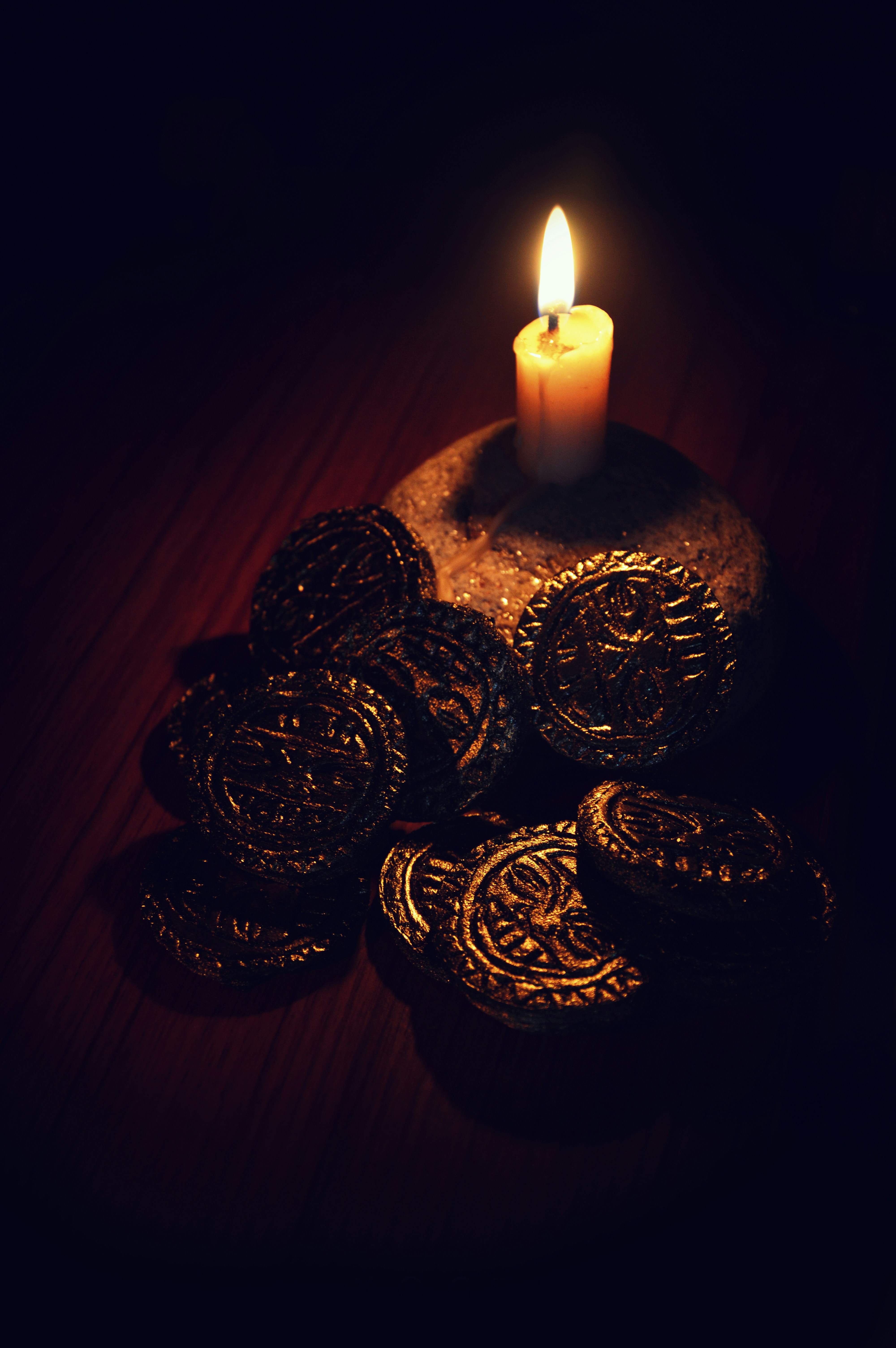 Candlelit coins: a quiet glow over a small treasure
