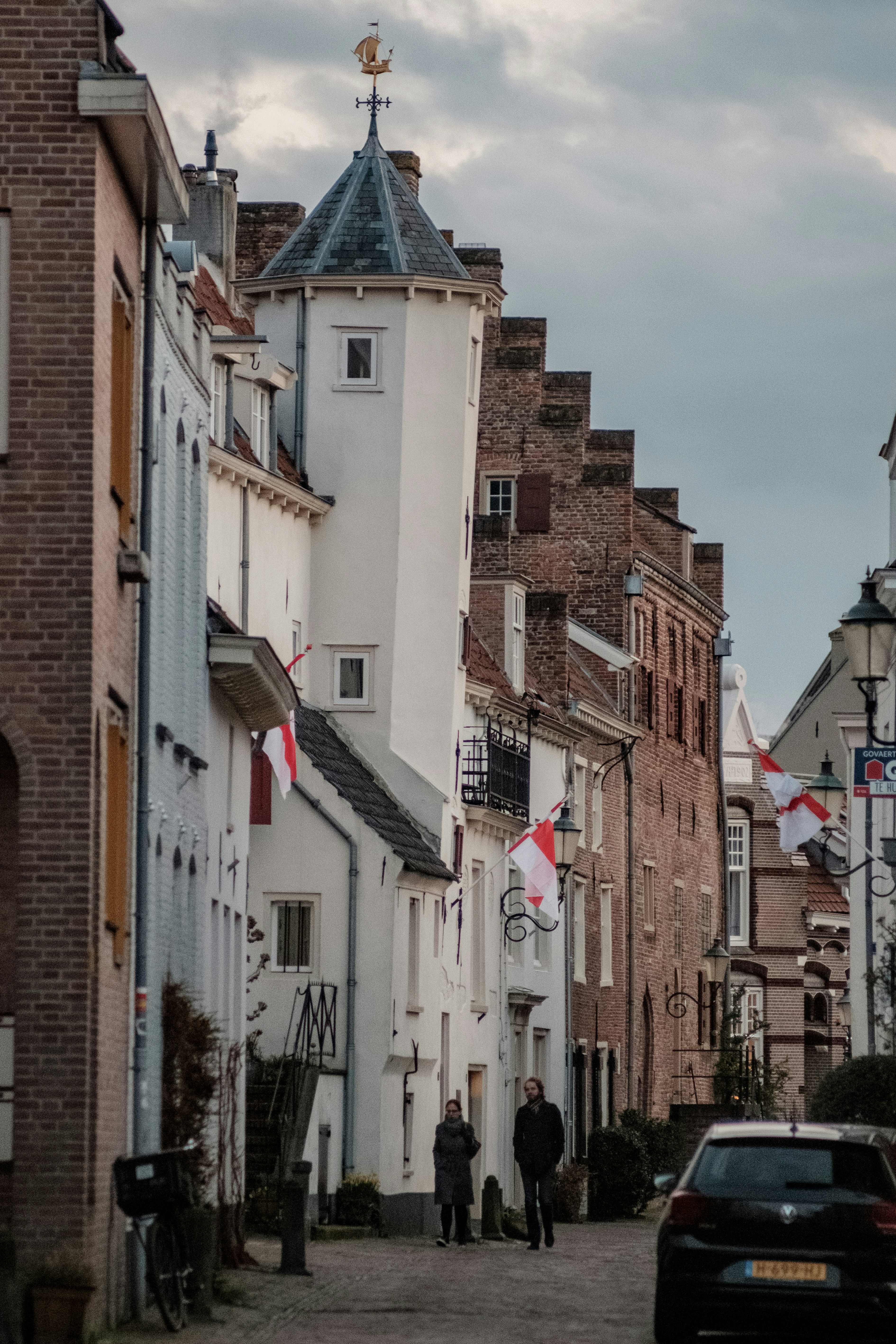 Charming street scene featuring traditional architecture and flags fluttering, showcasing the character of a historic town.