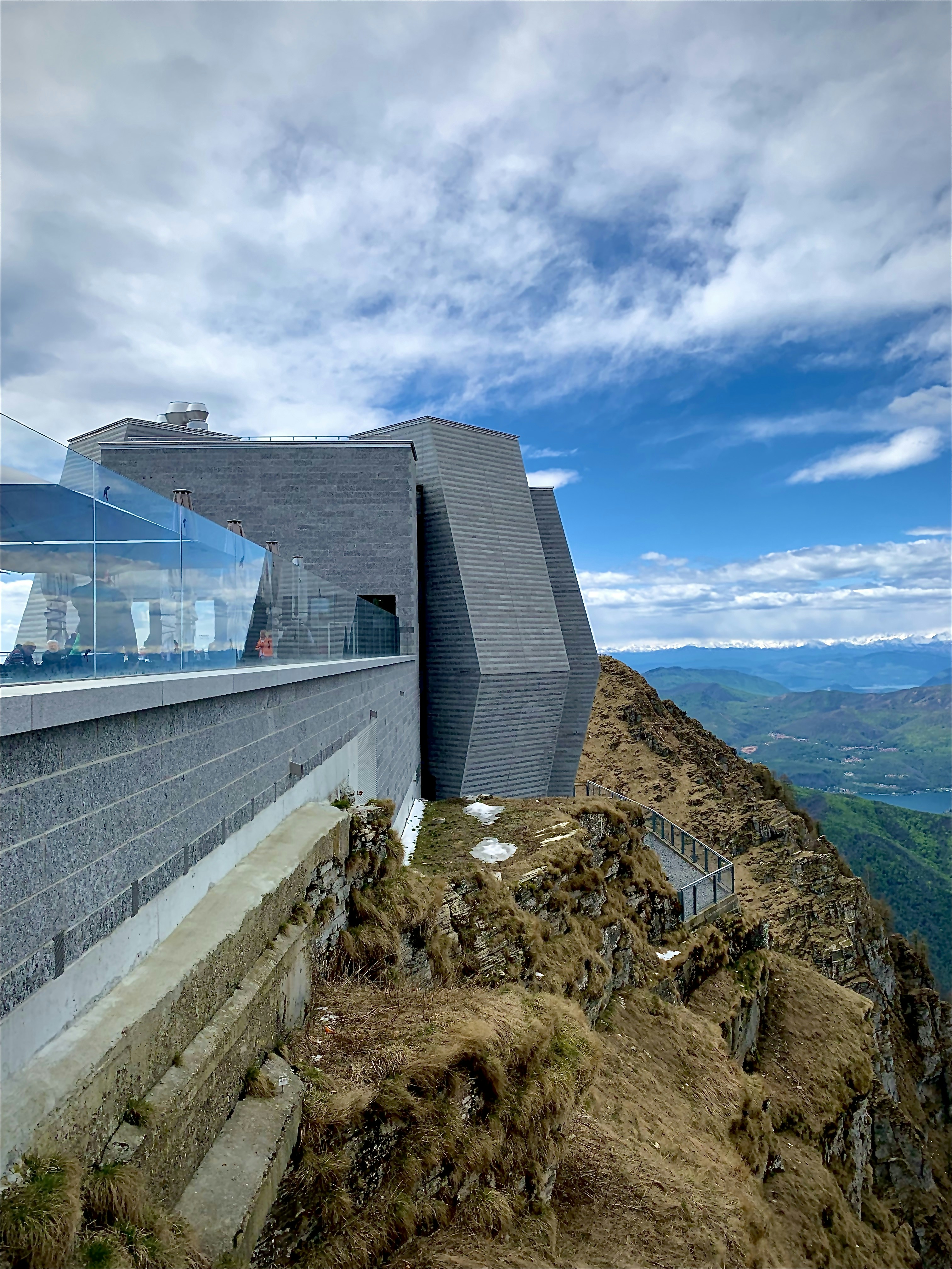 gray concrete building near green grass field under blue sky during daytime
