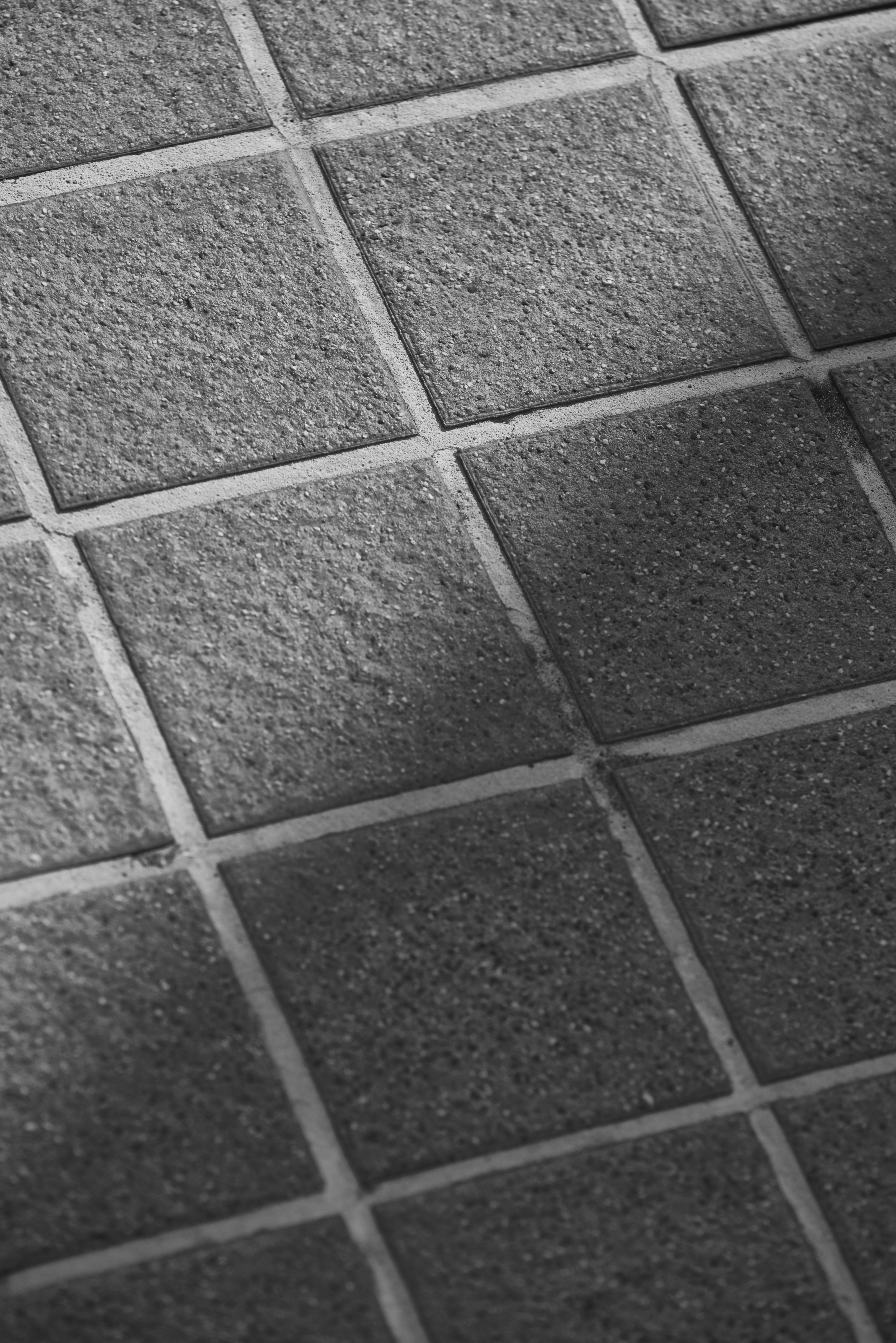 Close-up view of a tiled surface showcasing intricate patterns created by light and shadow.