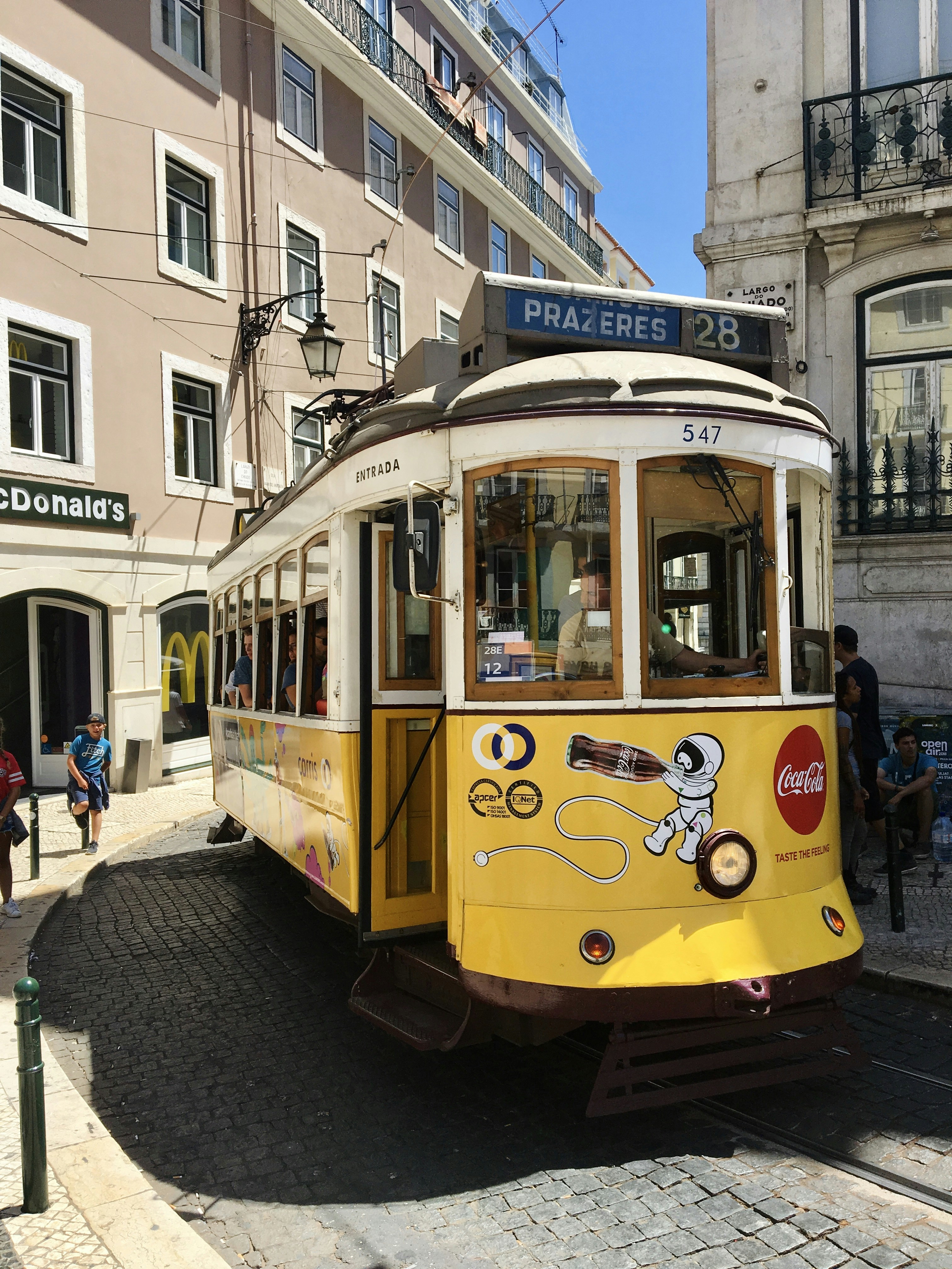 Prazeres 28: A Sunlit Yellow Tram on Lisbon's Cobblestones