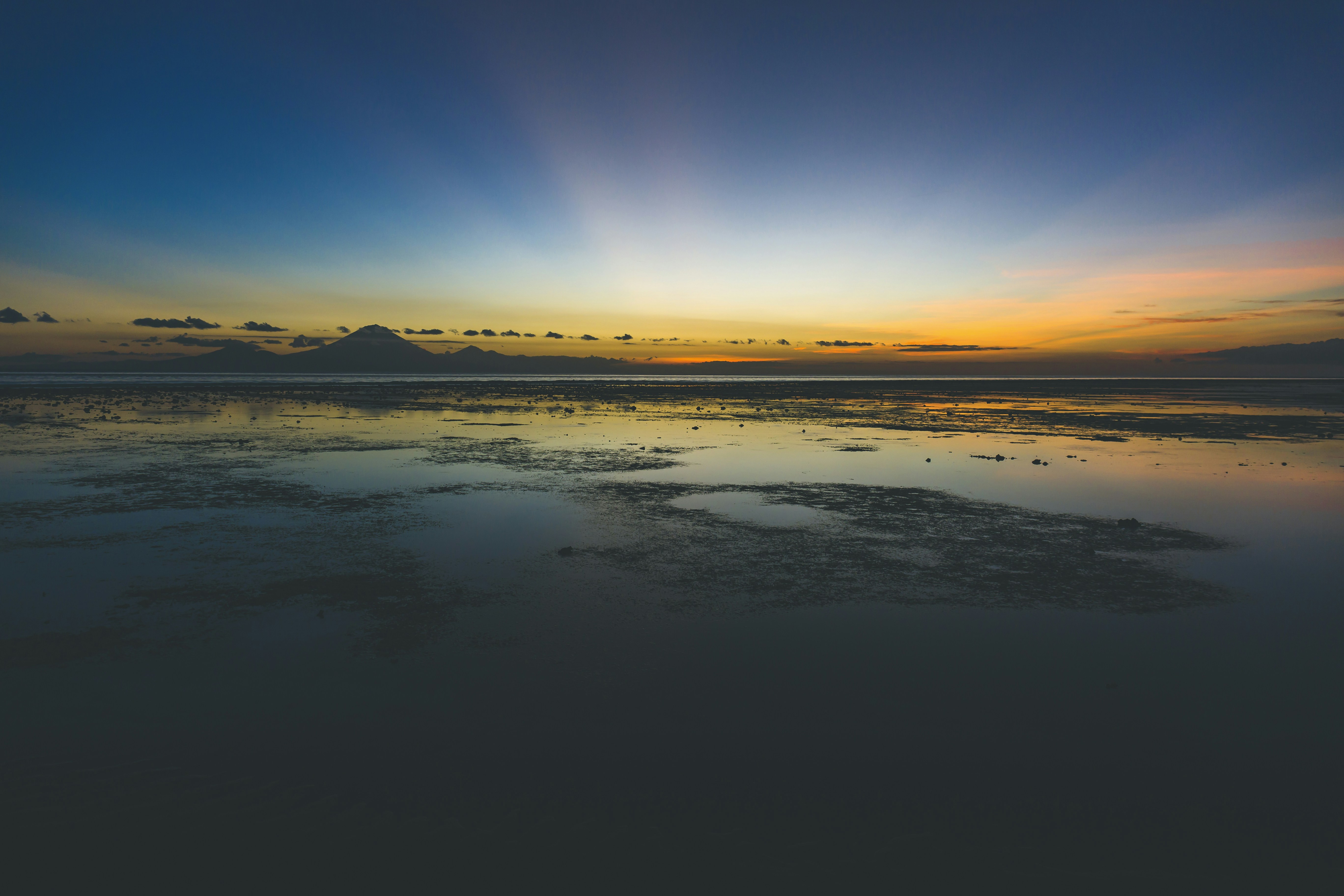 Horizon in Glass: Sunset Quietly Unfolds Across a Glassy Tidal Flat