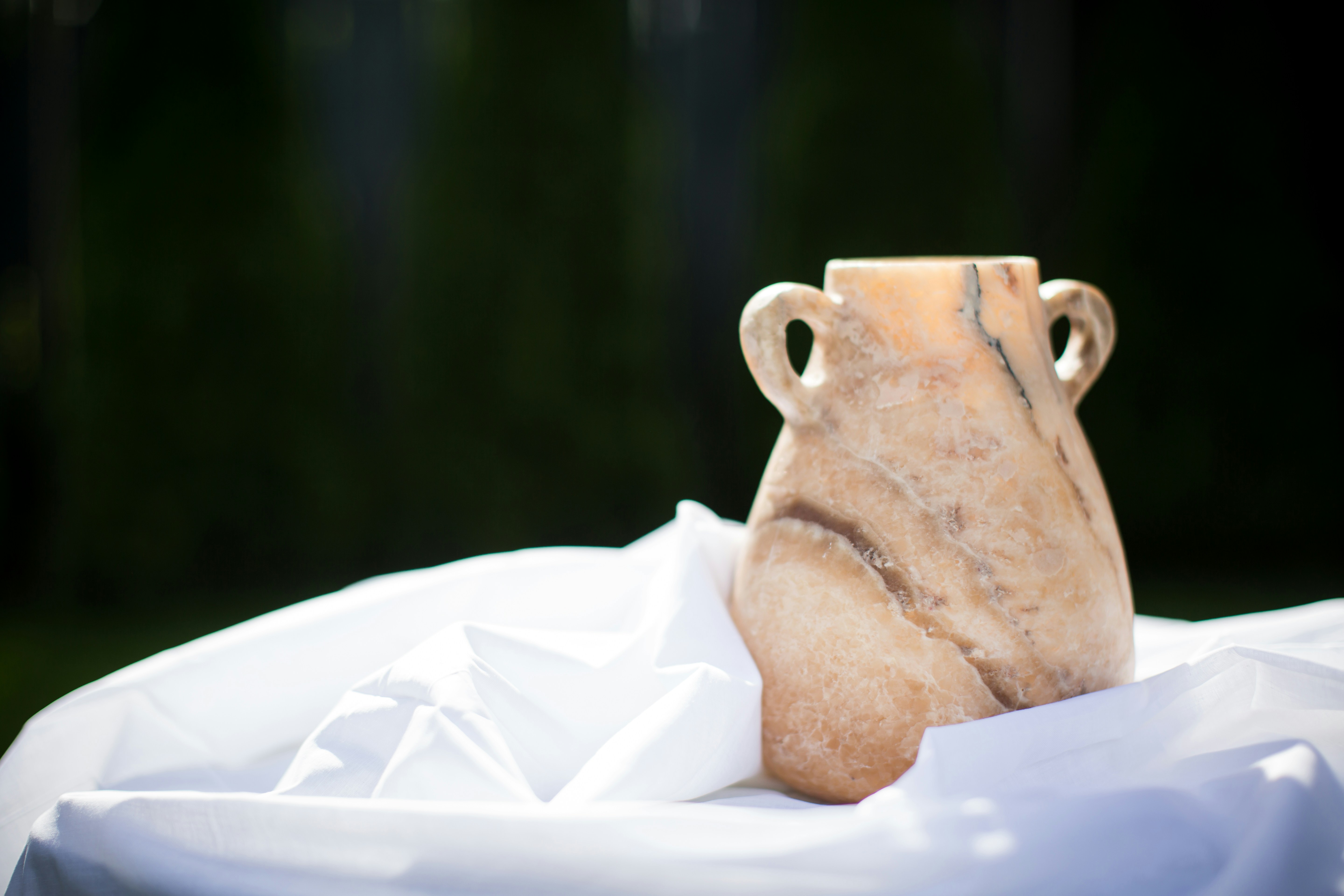 Stoneware in Soft Light: A lone amphora amid white folds