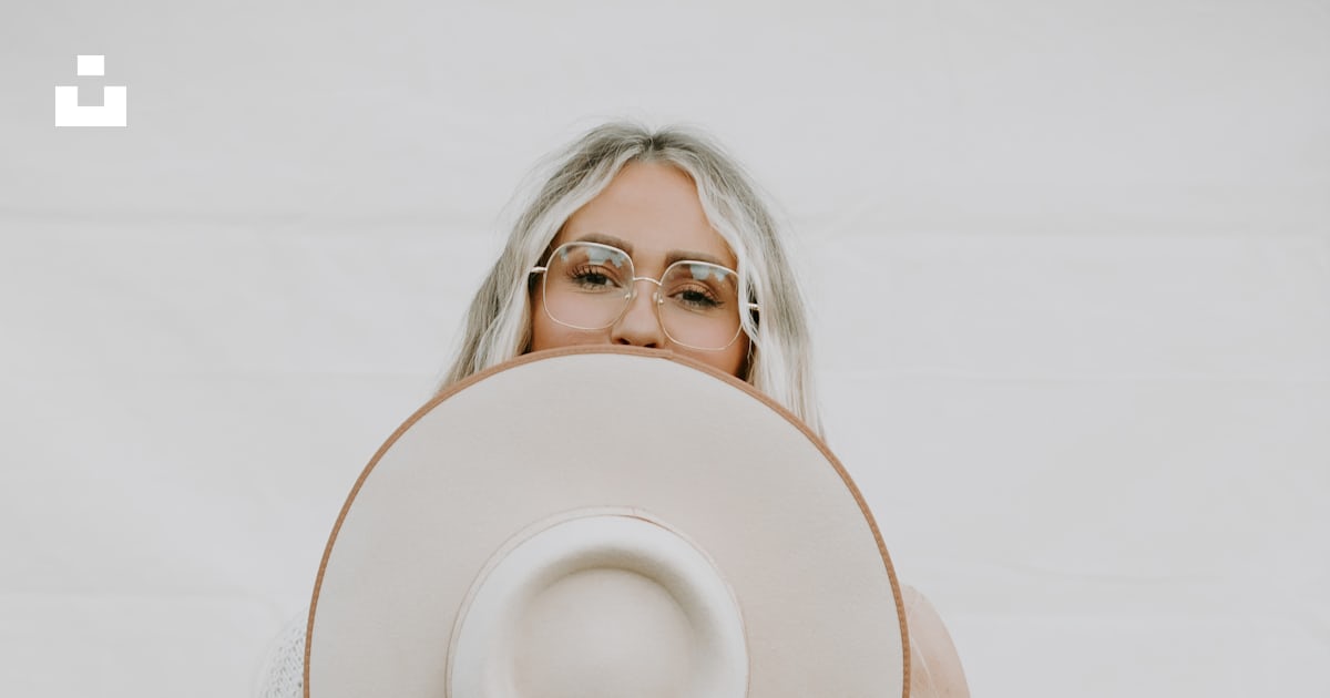 白いセーターと青いデニムジーンズを着た女性が白いフェドーラ帽をかぶっているの写真 Unsplashのファッションの無料画像