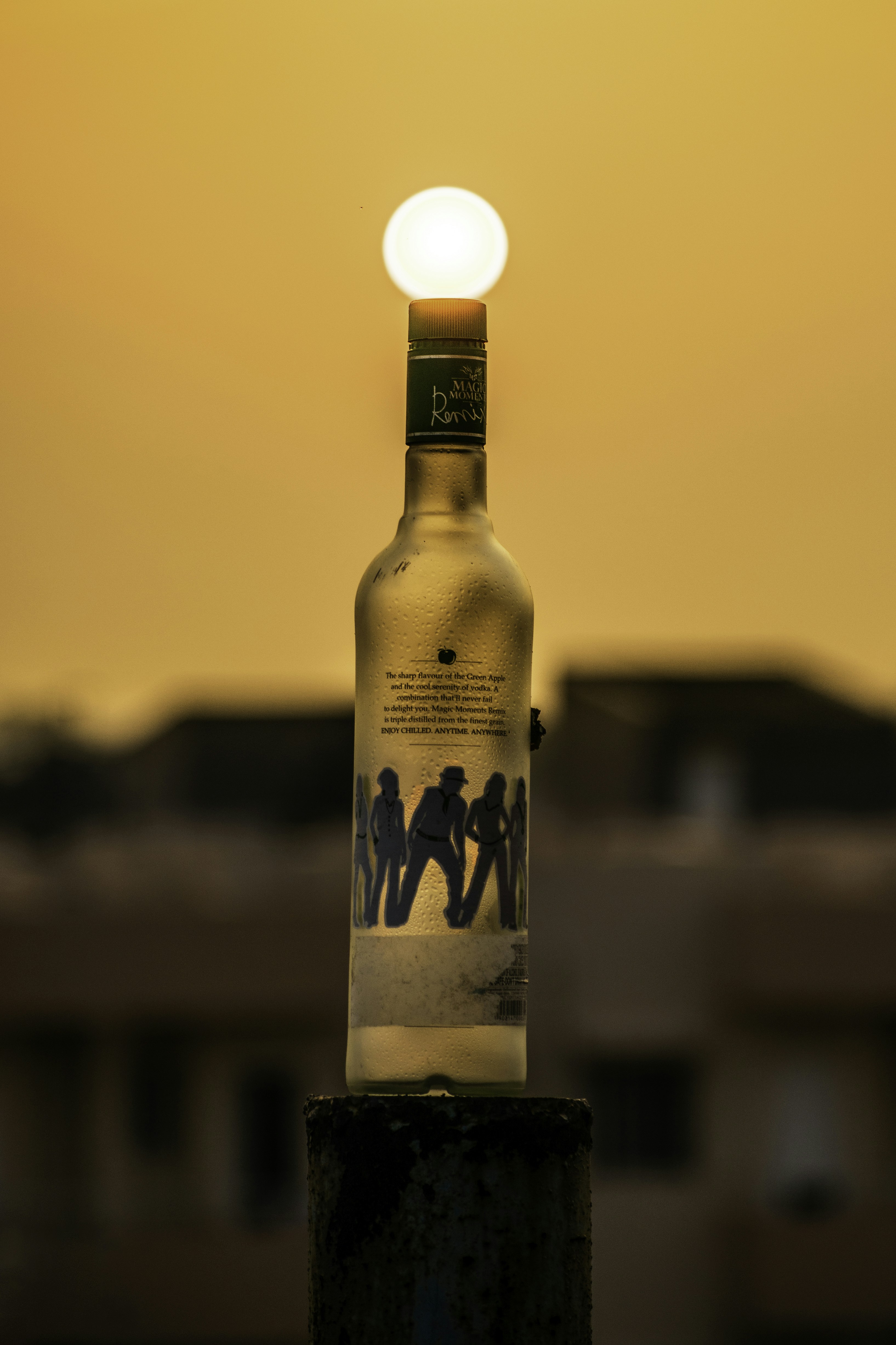 Sunset Crown on a Weathered Pedestal: A Frosted Bottle Under a Golden Halo