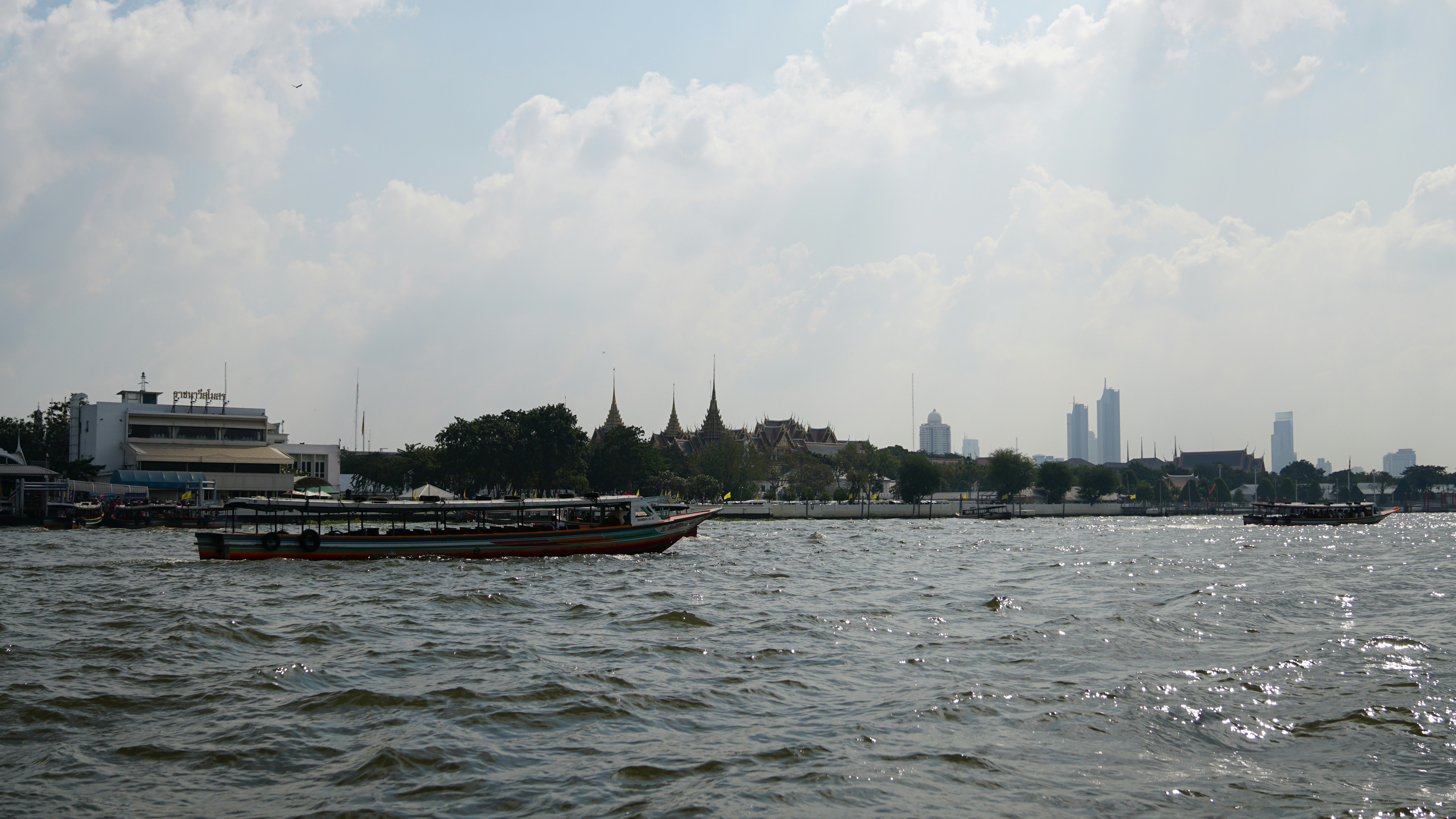 red and black boat on water near city buildings during daytime