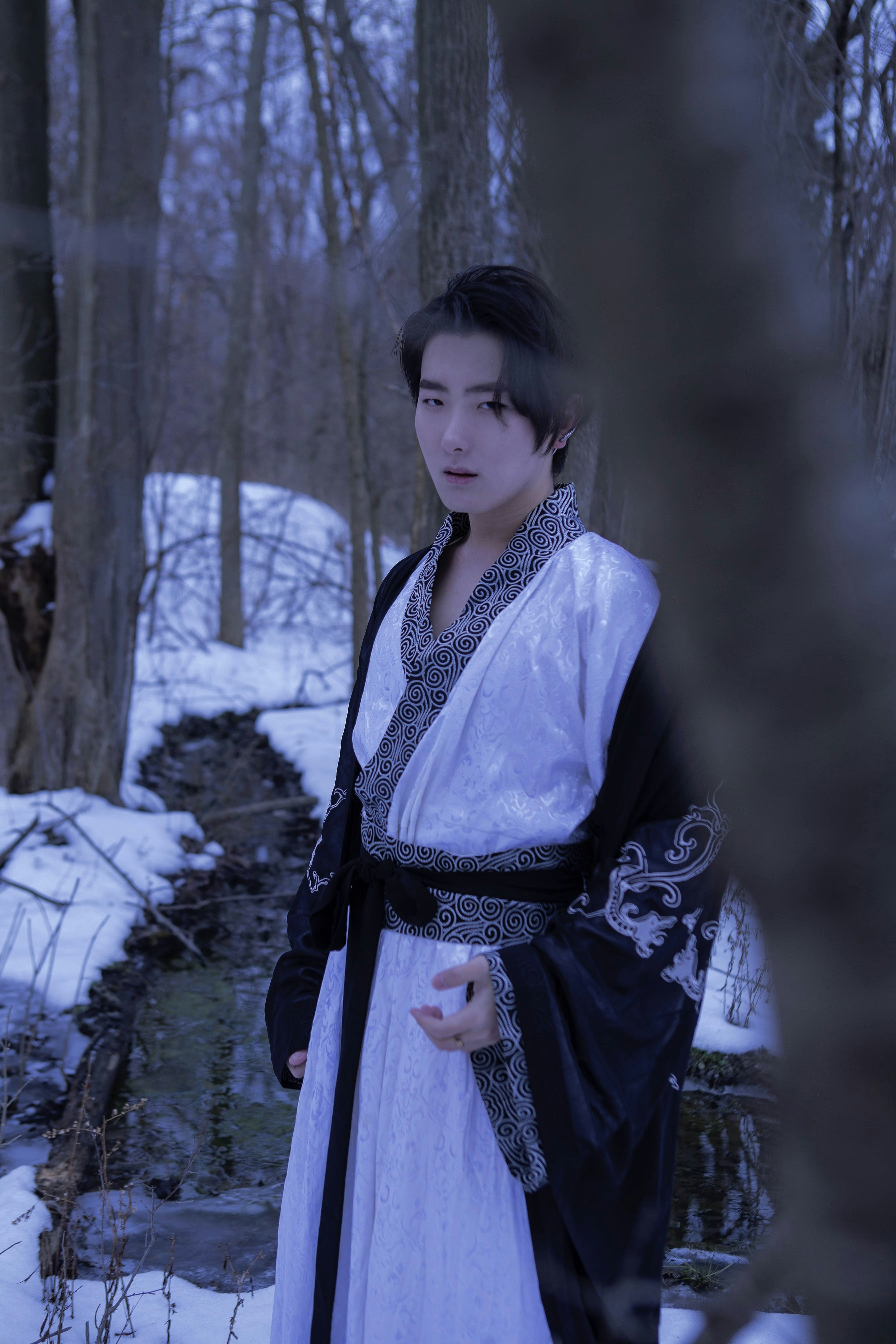 Woman in black and white floral kimono standing on snow covered ground ...