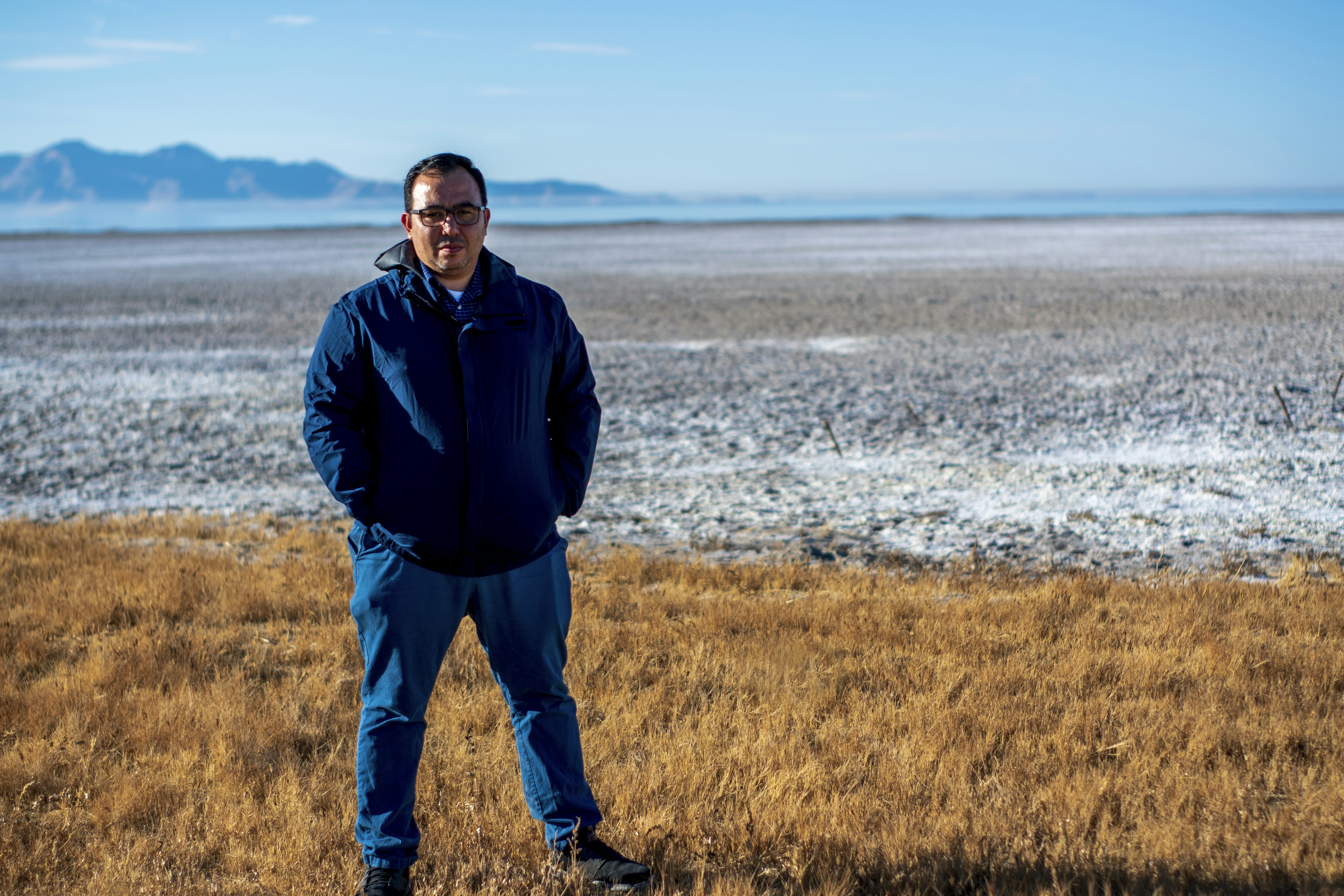 Blue Jacket on the Salt Grass: Portrait Against a Distant Coastal Range