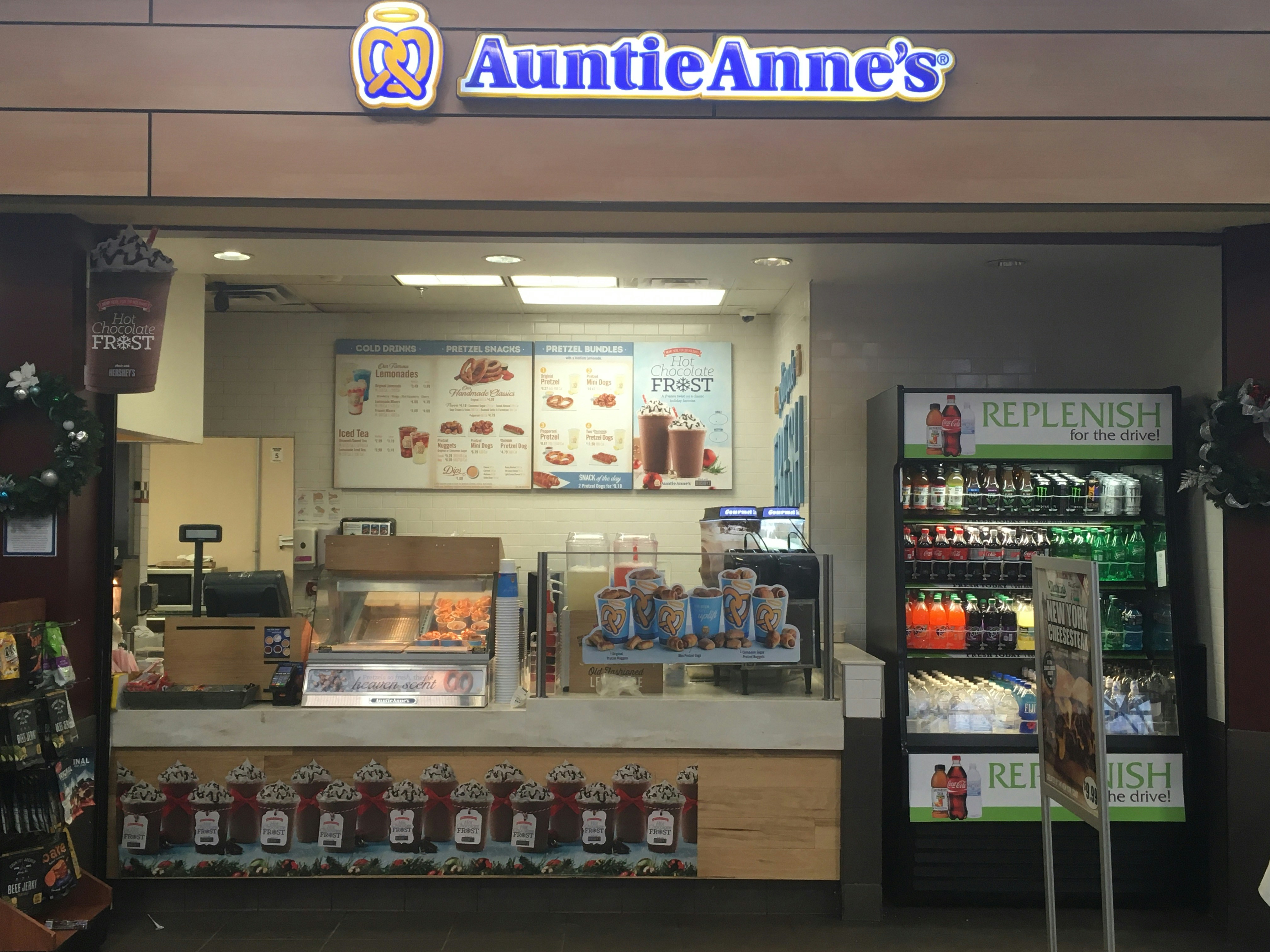Auntie Anne's kiosk featuring a variety of pretzel options and beverages in a vibrant mall setting.