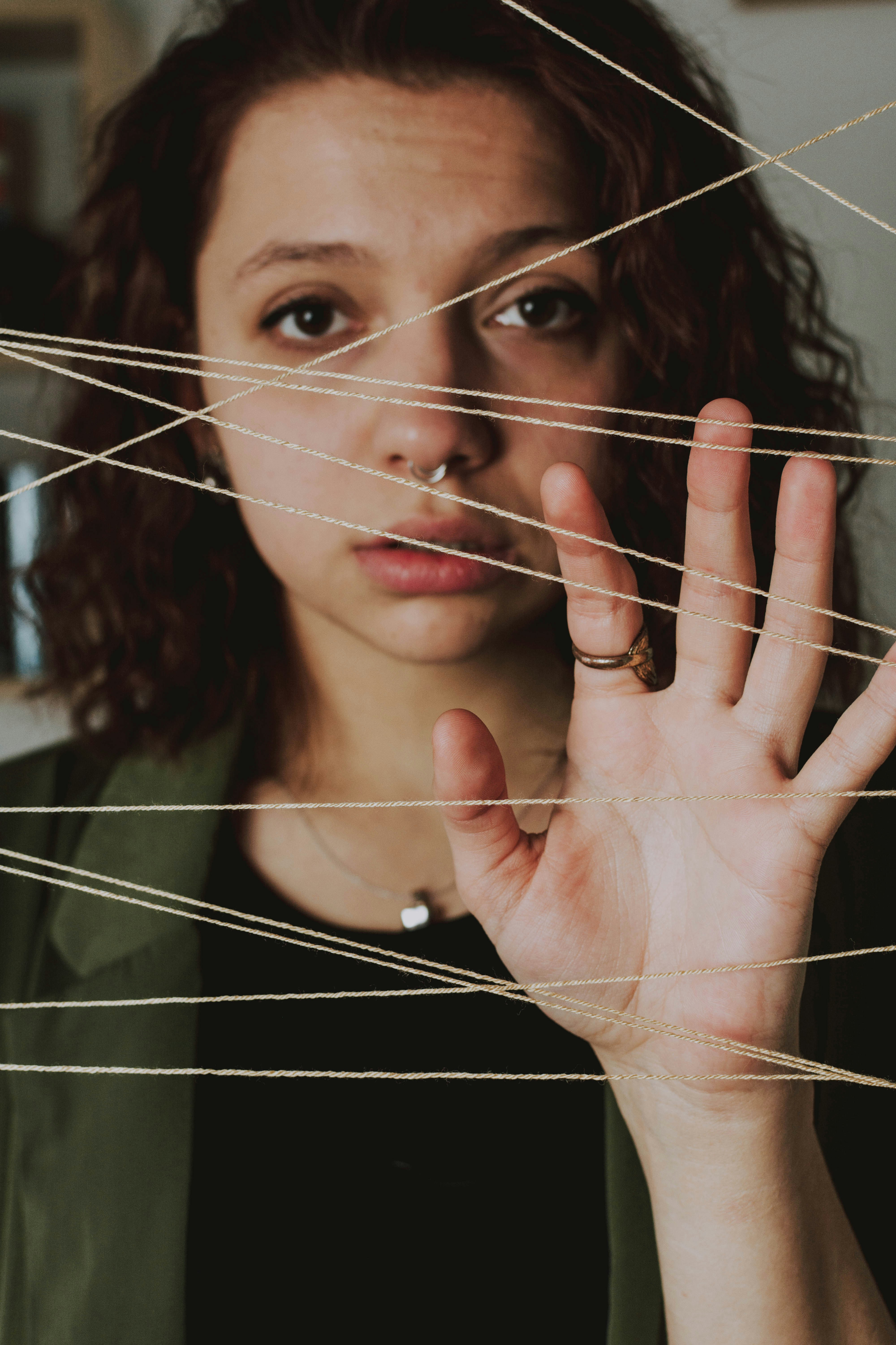 Hands of Confinement: A Soft Portrait Veiled by String