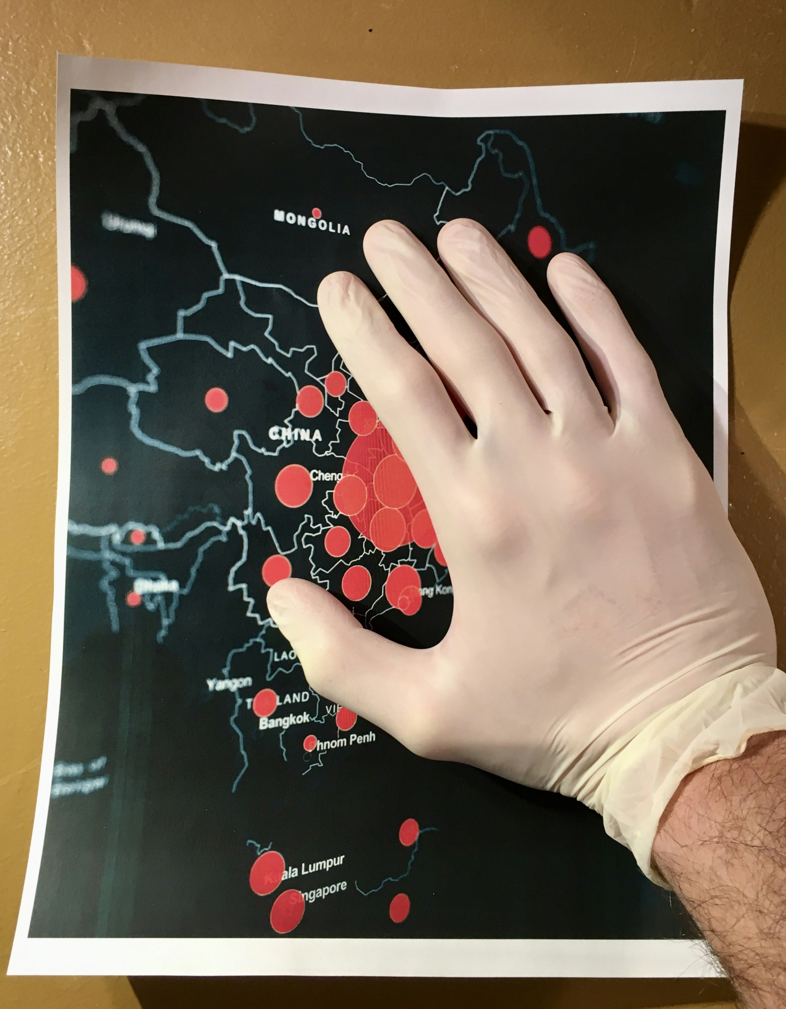 Gloved Hand Over a Dotted Asia Map