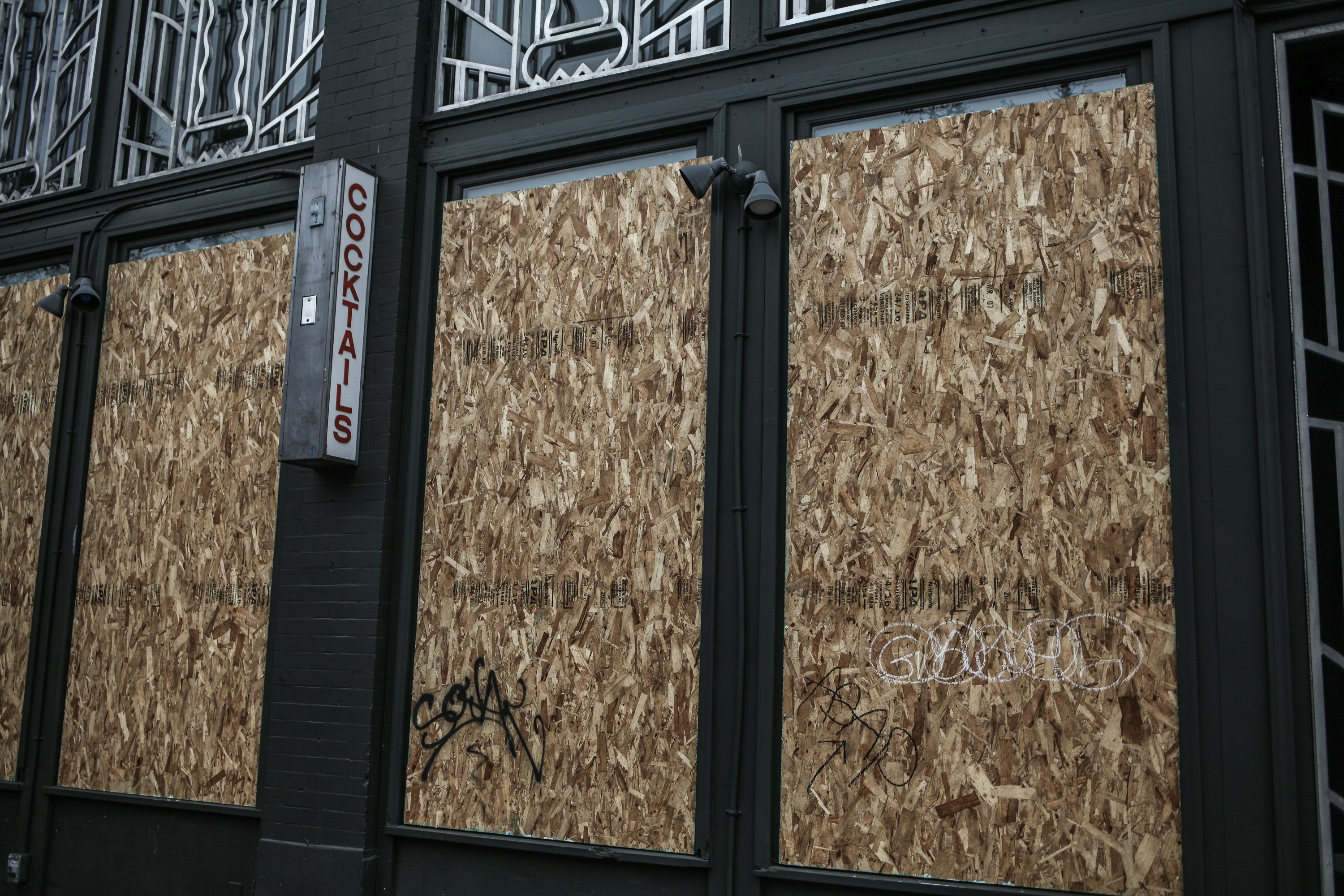 Closed for the Night: Vertical Cocktails Sign Anchors a Boarded-Up Facade