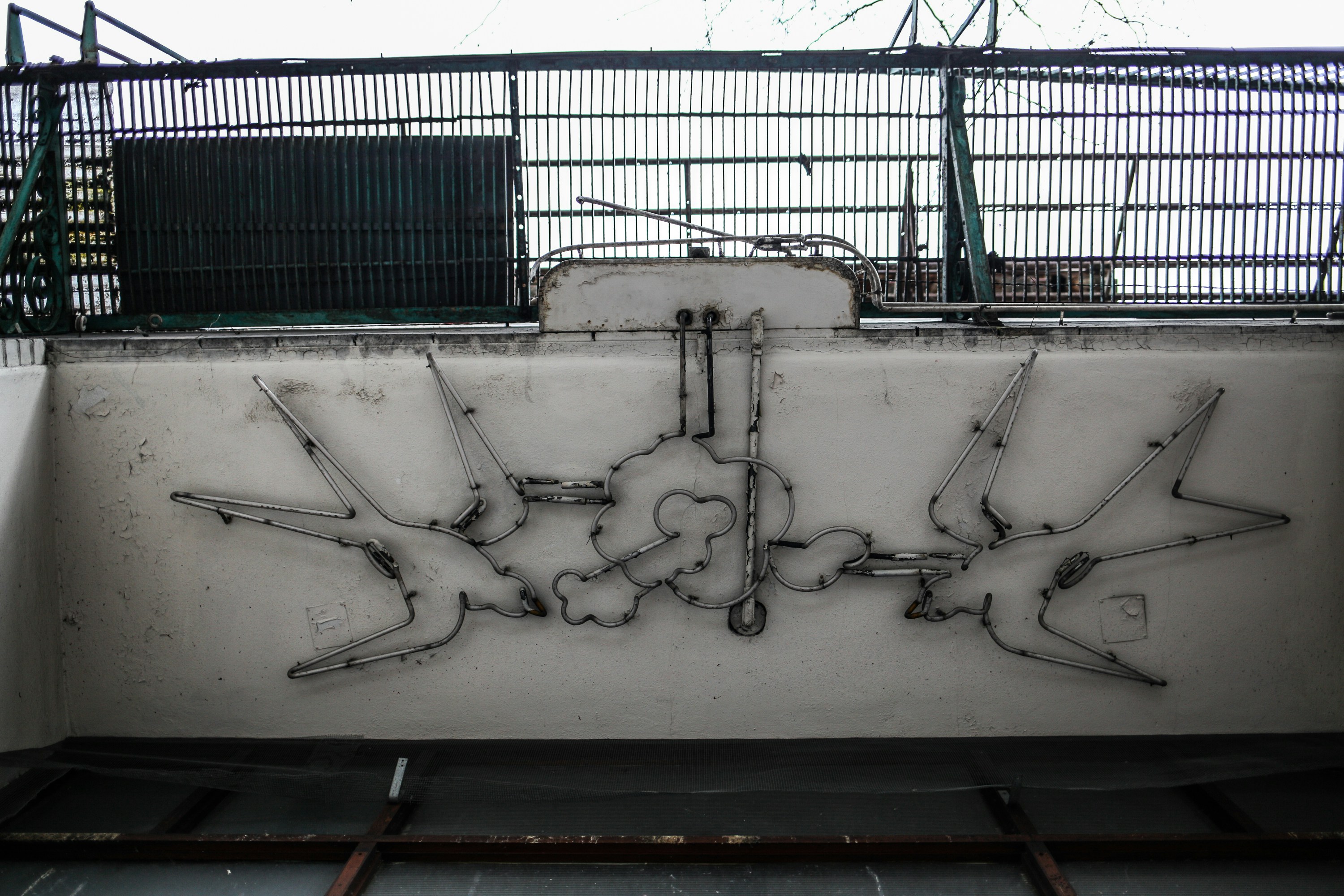 Twin Line-Drawn Seabirds Flank a Central Cloud on a Weathered Harbor Wall