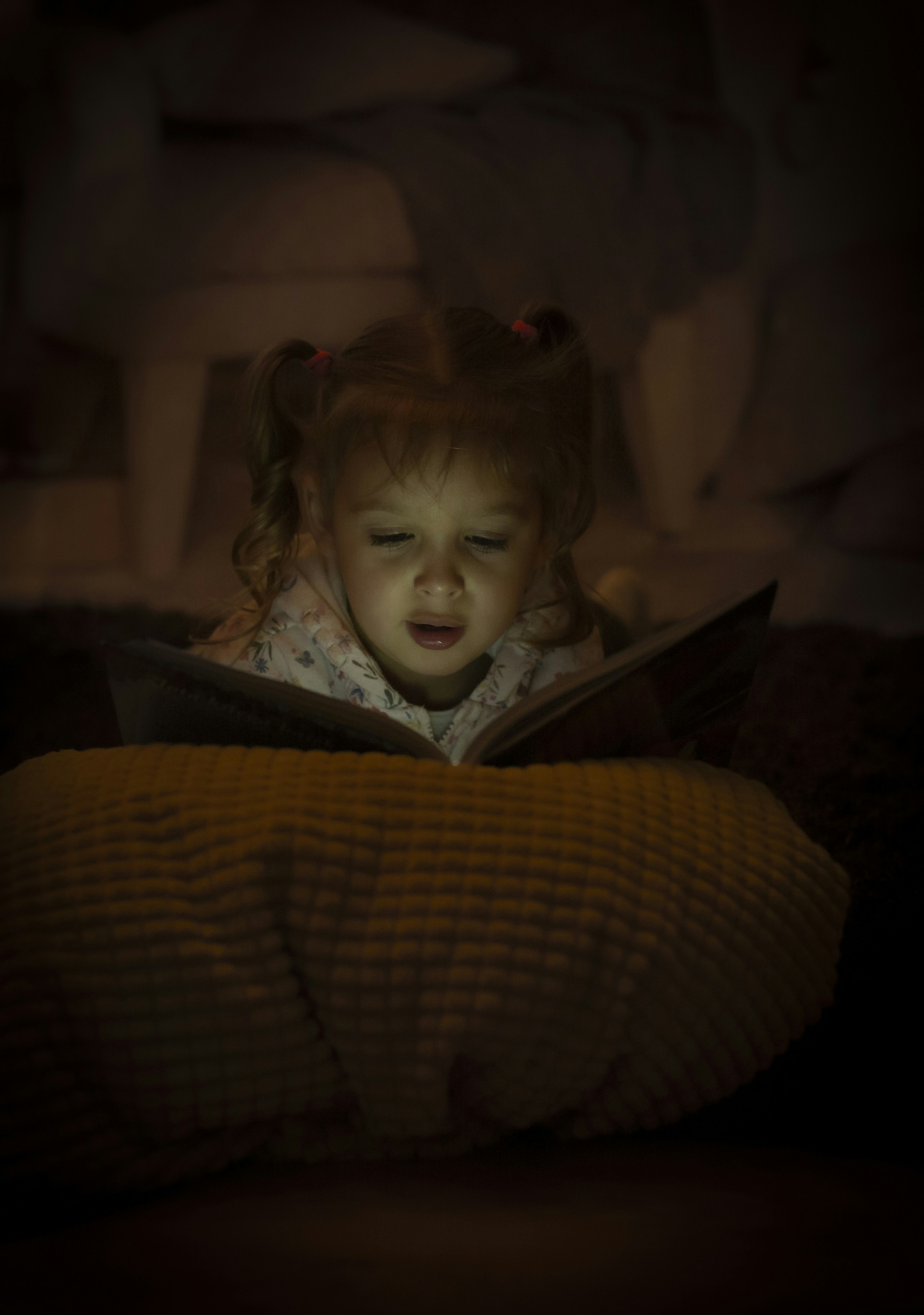 Ember Glow: A Little Reader Immersed in a Nighttime Page