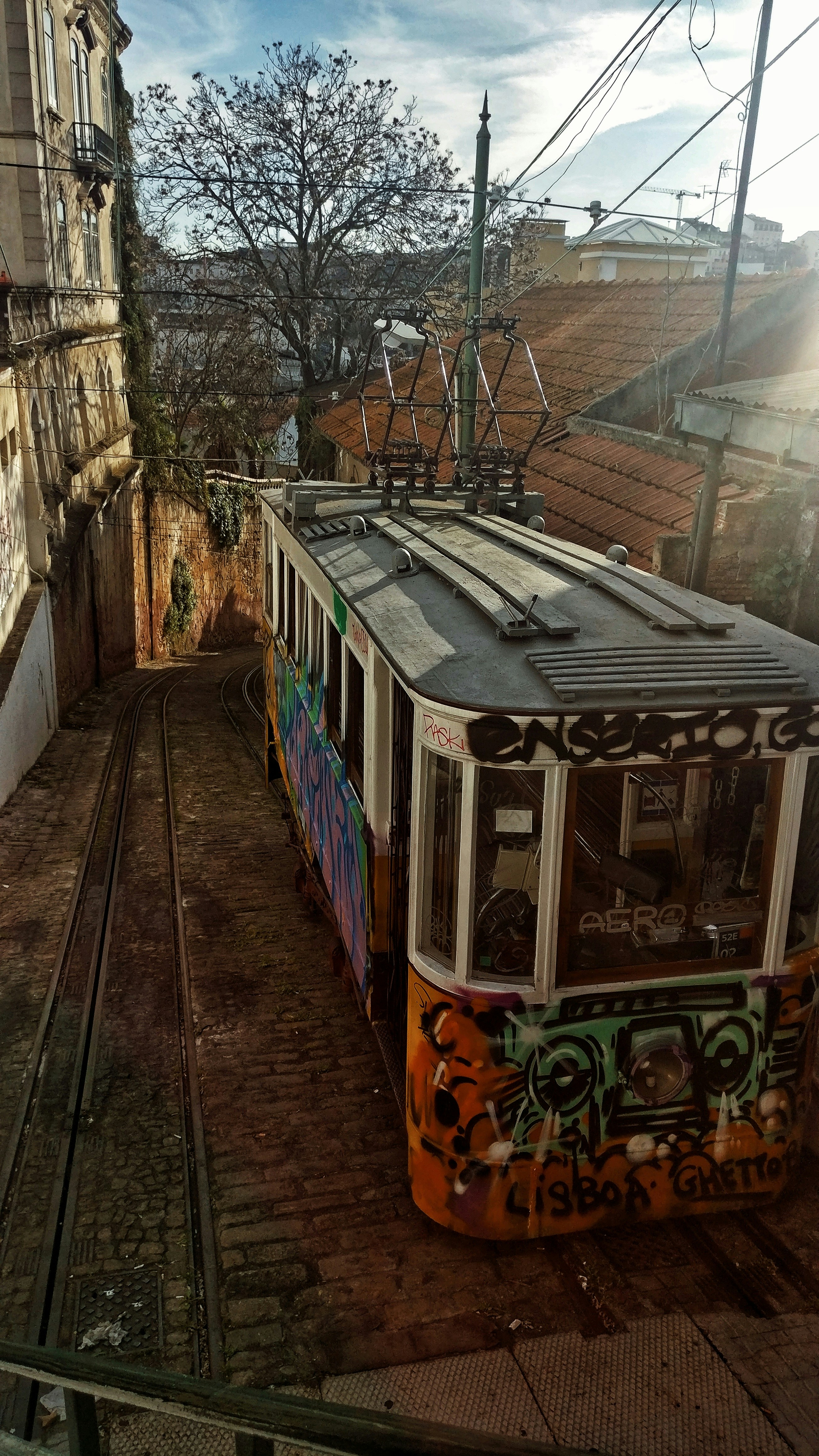 Lisbon's Graffiti-Laced Tram Rounds a Sunlit Curved Track