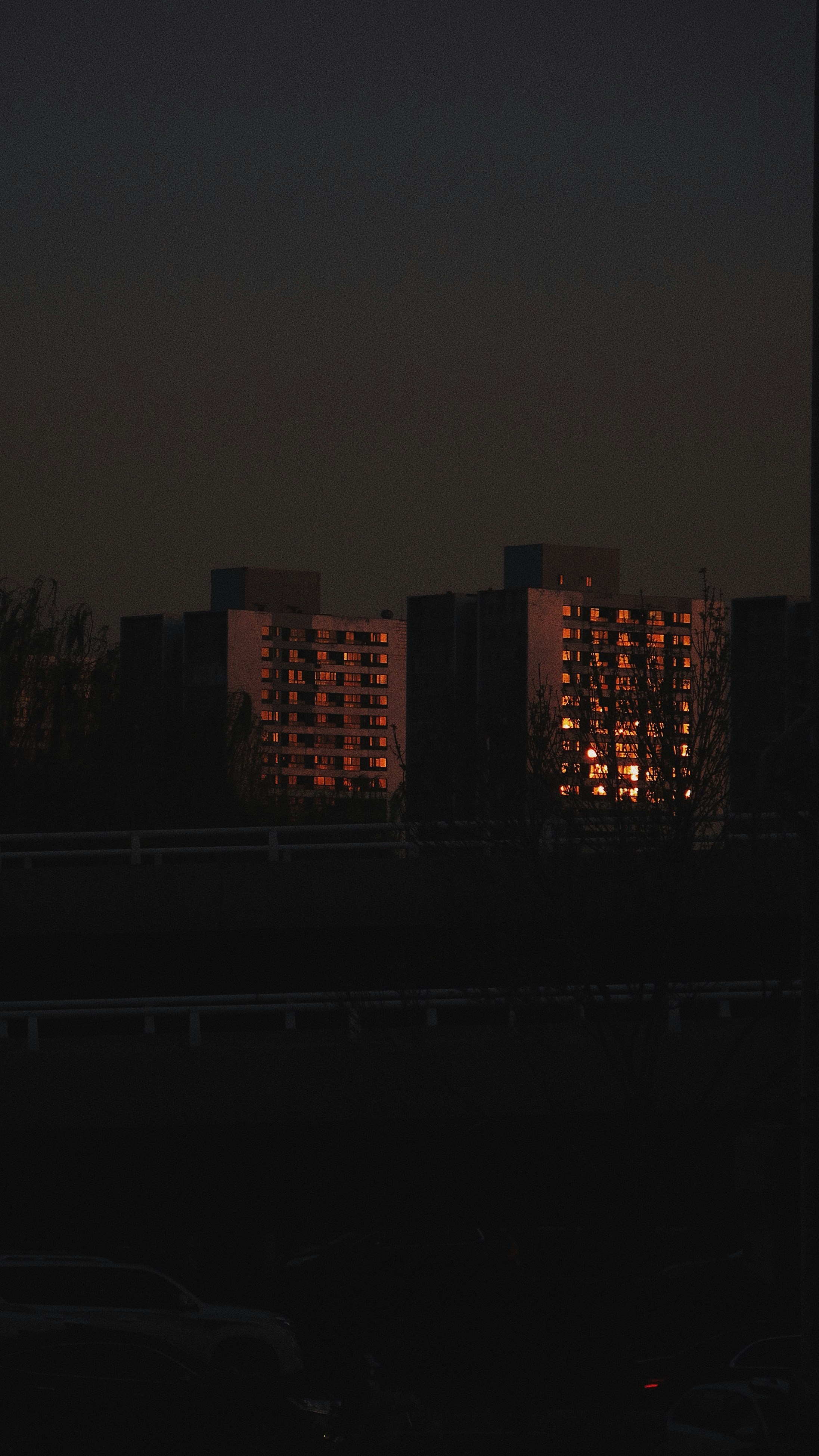 Sunset reflecting off the windows of high-rise buildings, creating a warm glow against the twilight sky.