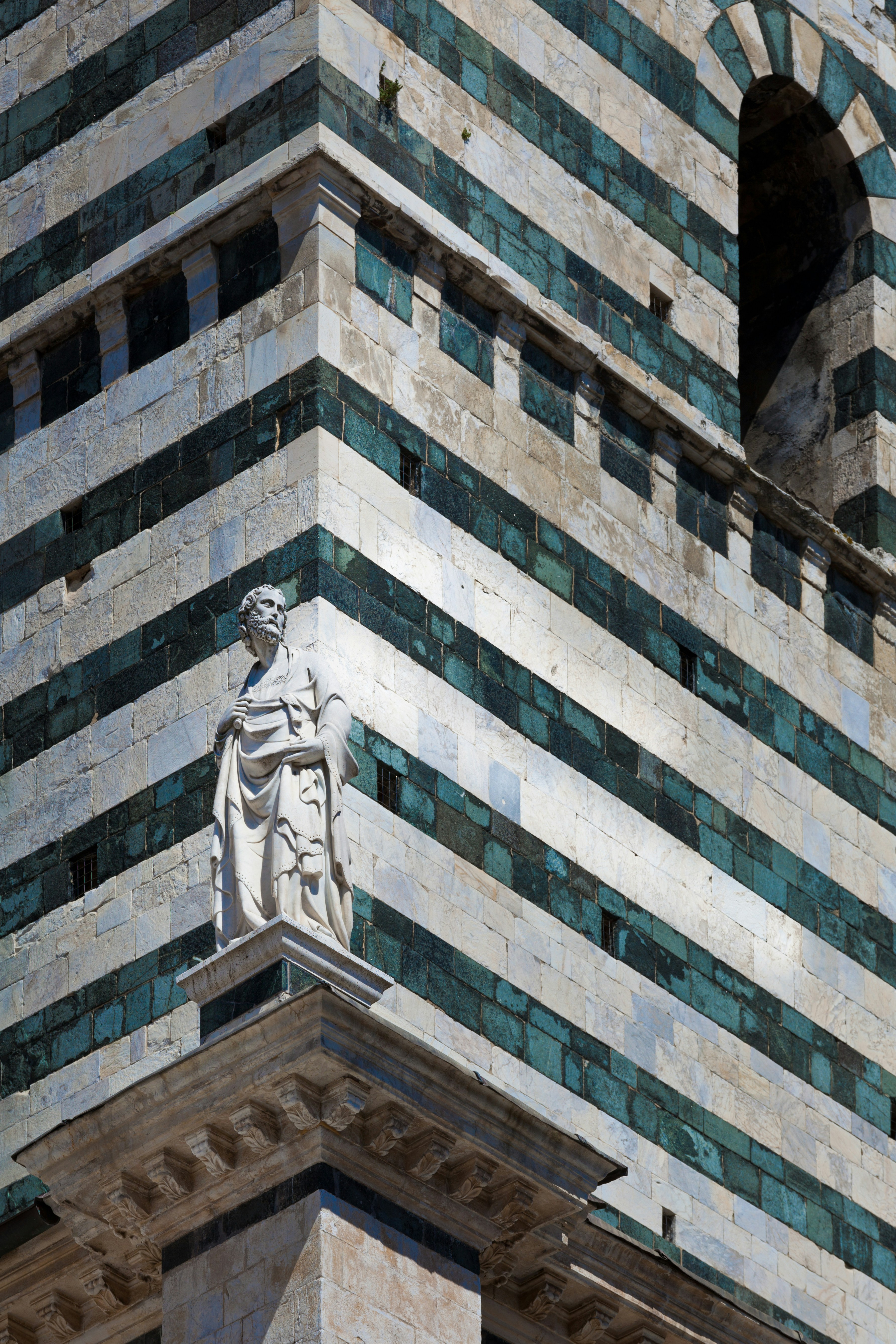 Statue Guardian on a Striped Marble Facade
