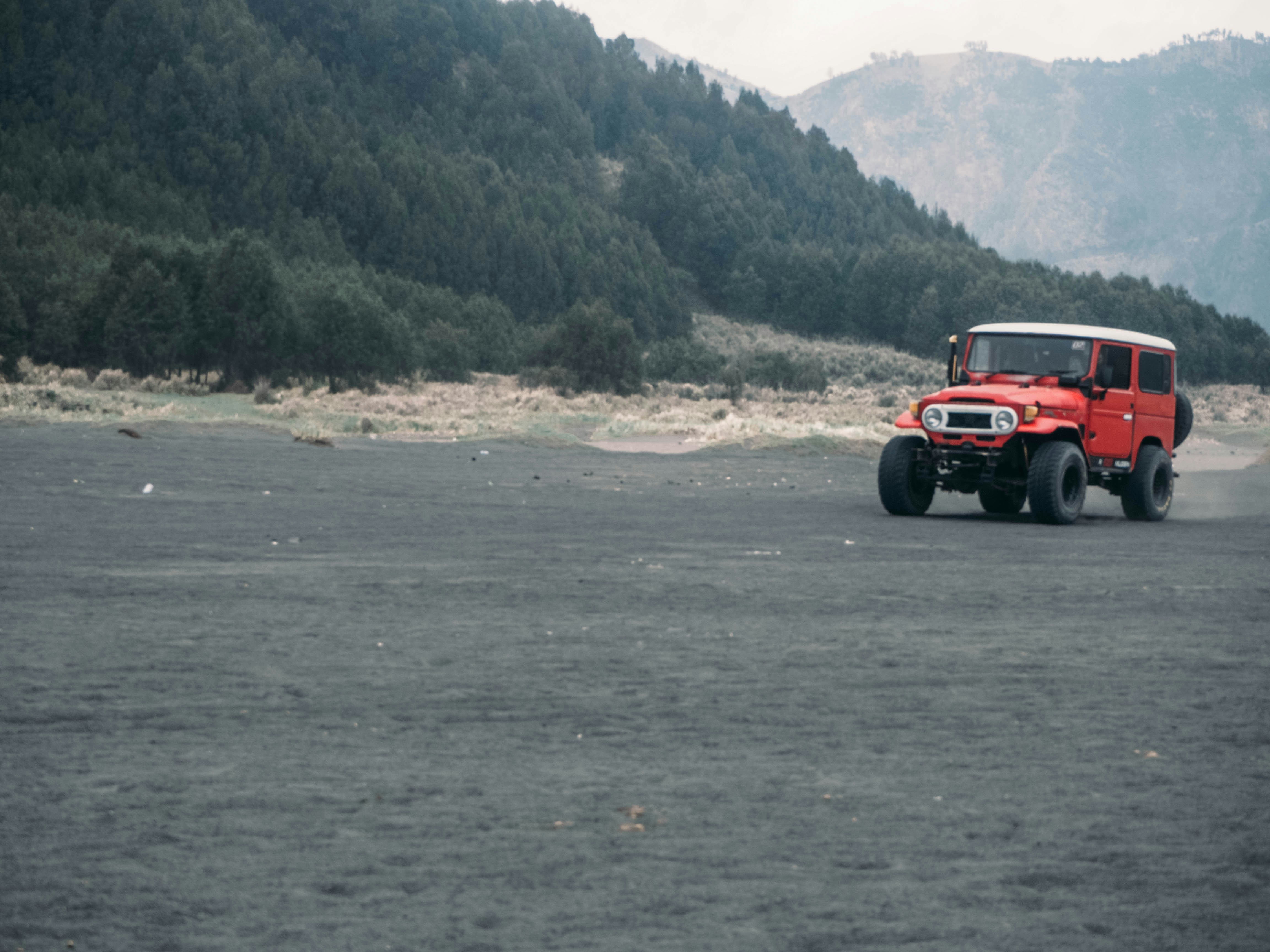 Red Jeep on a Desolate Shore: A Quiet Coastal Crossing