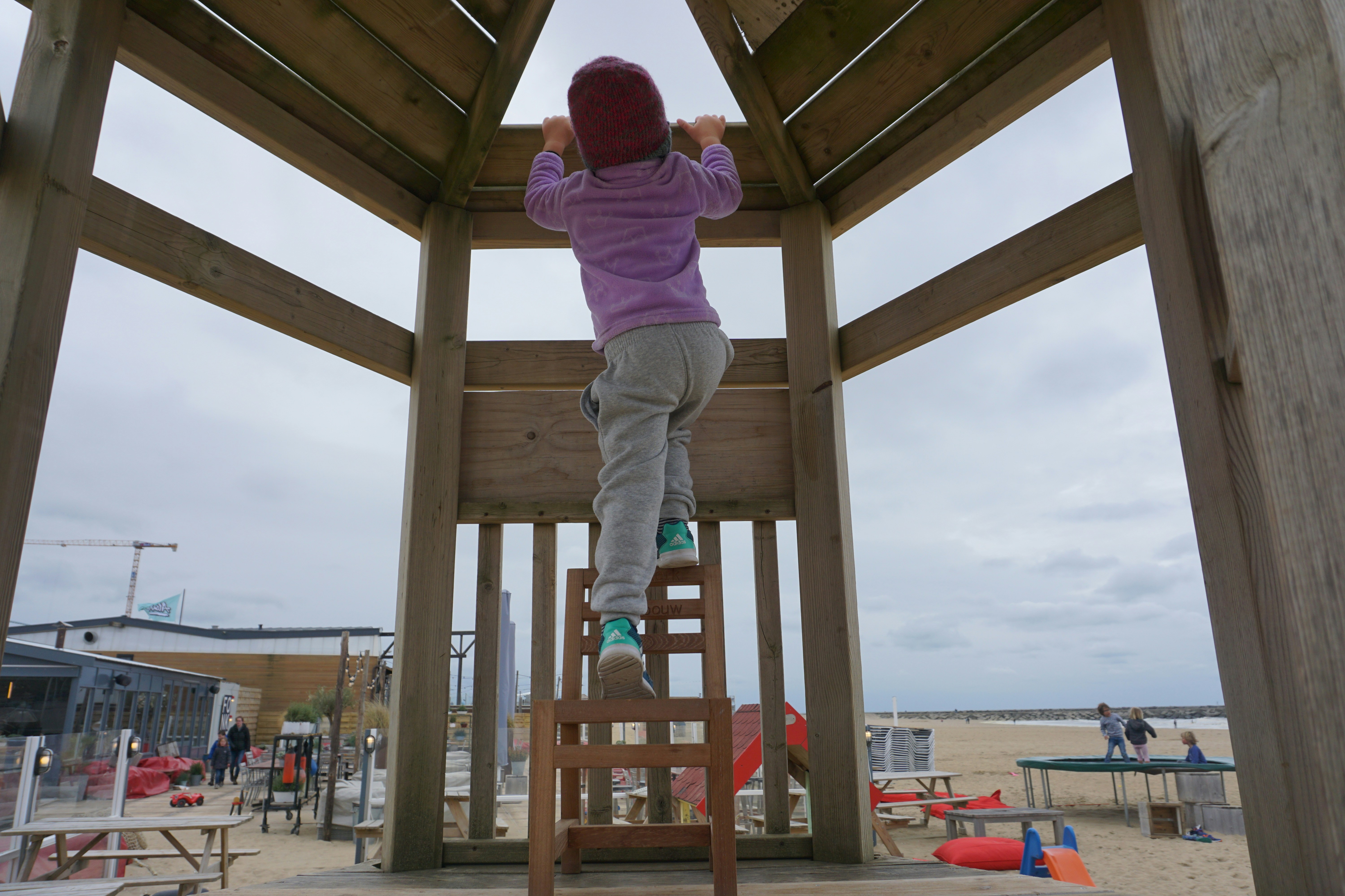 Ladder to the Sea Sky: Child Climbs a Wooden Beach Playhouse