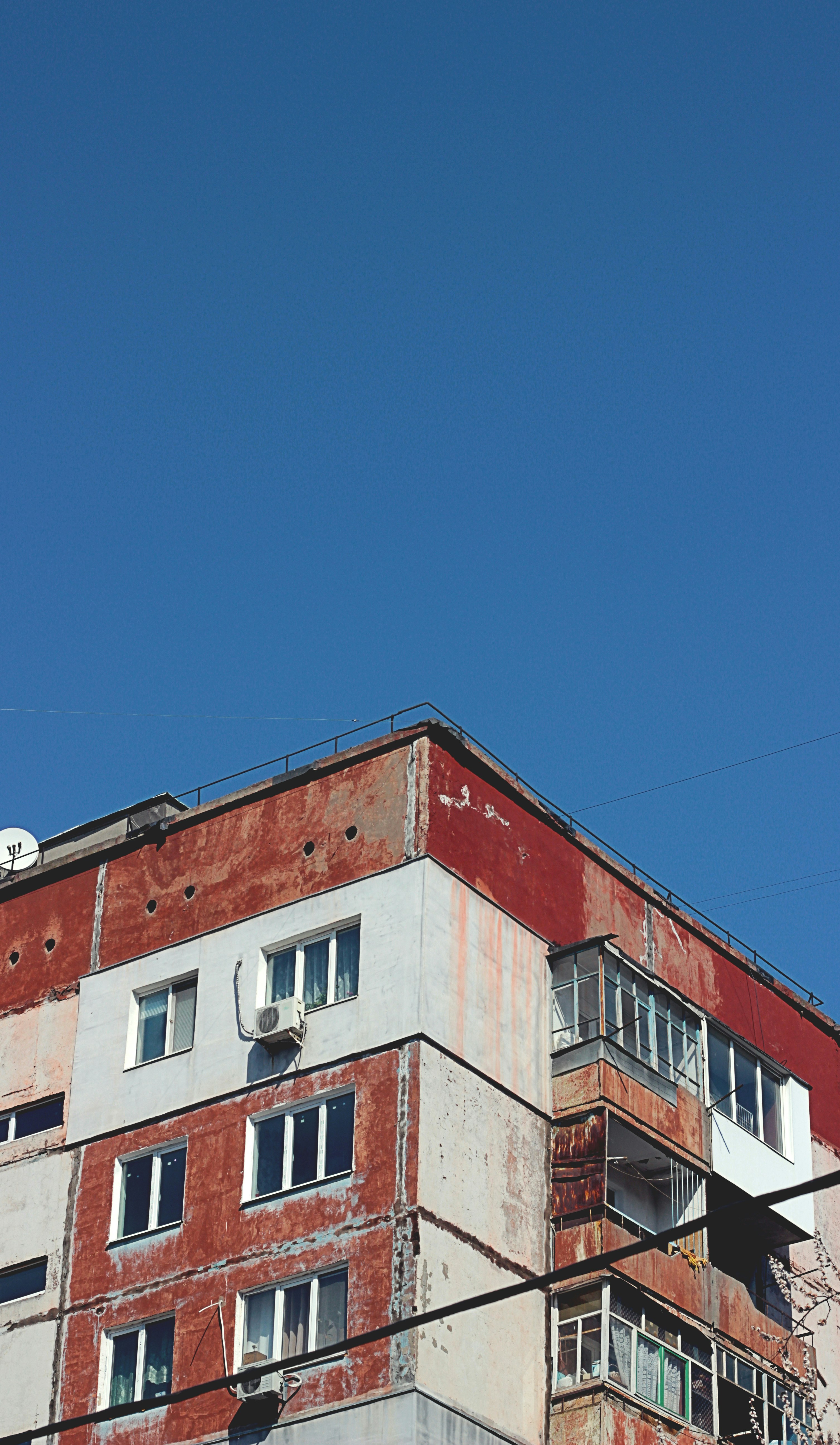 Crimson Facade Under Azure: The Weathered City Block