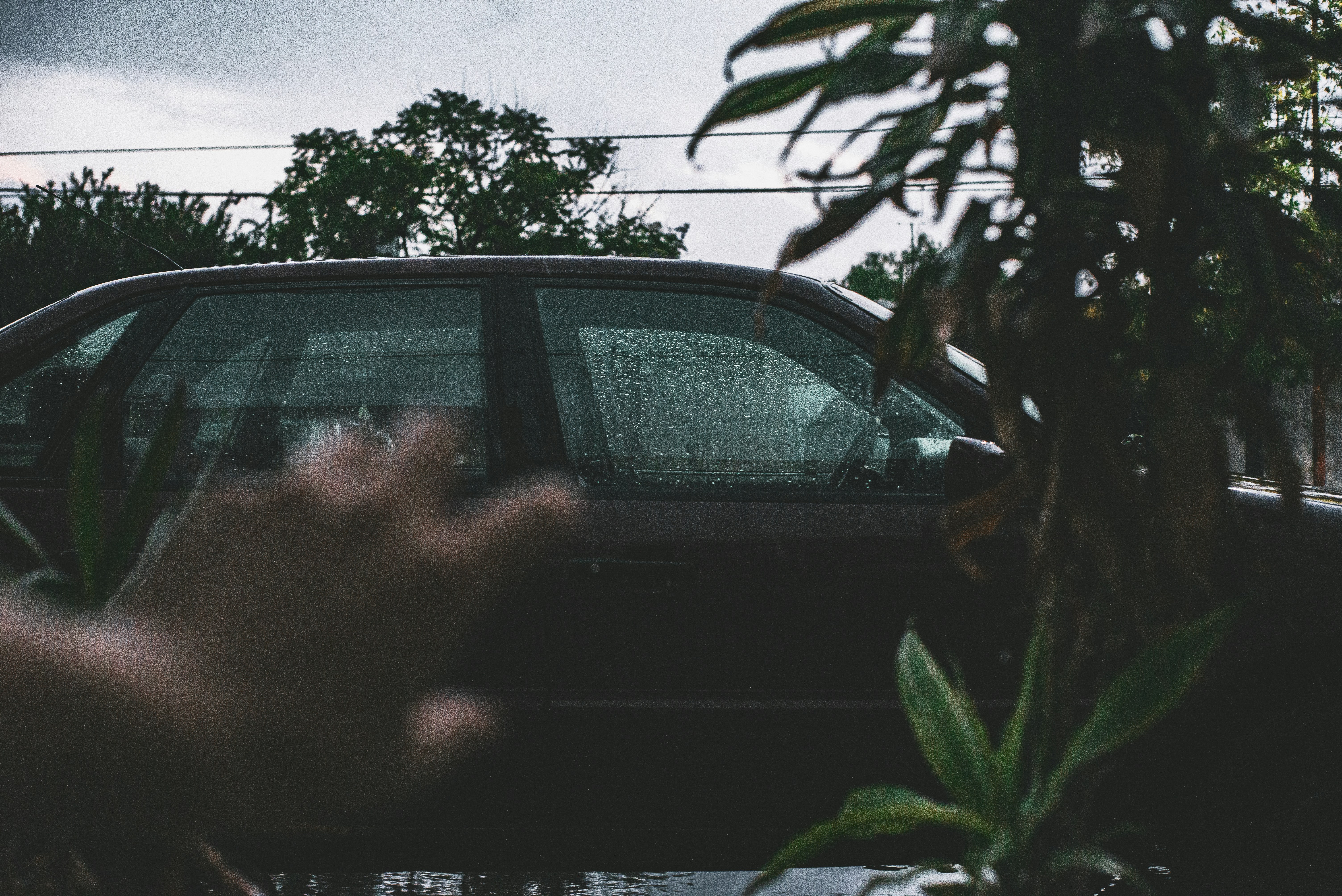 Rain-Slicked Car Window and Reaching Hand