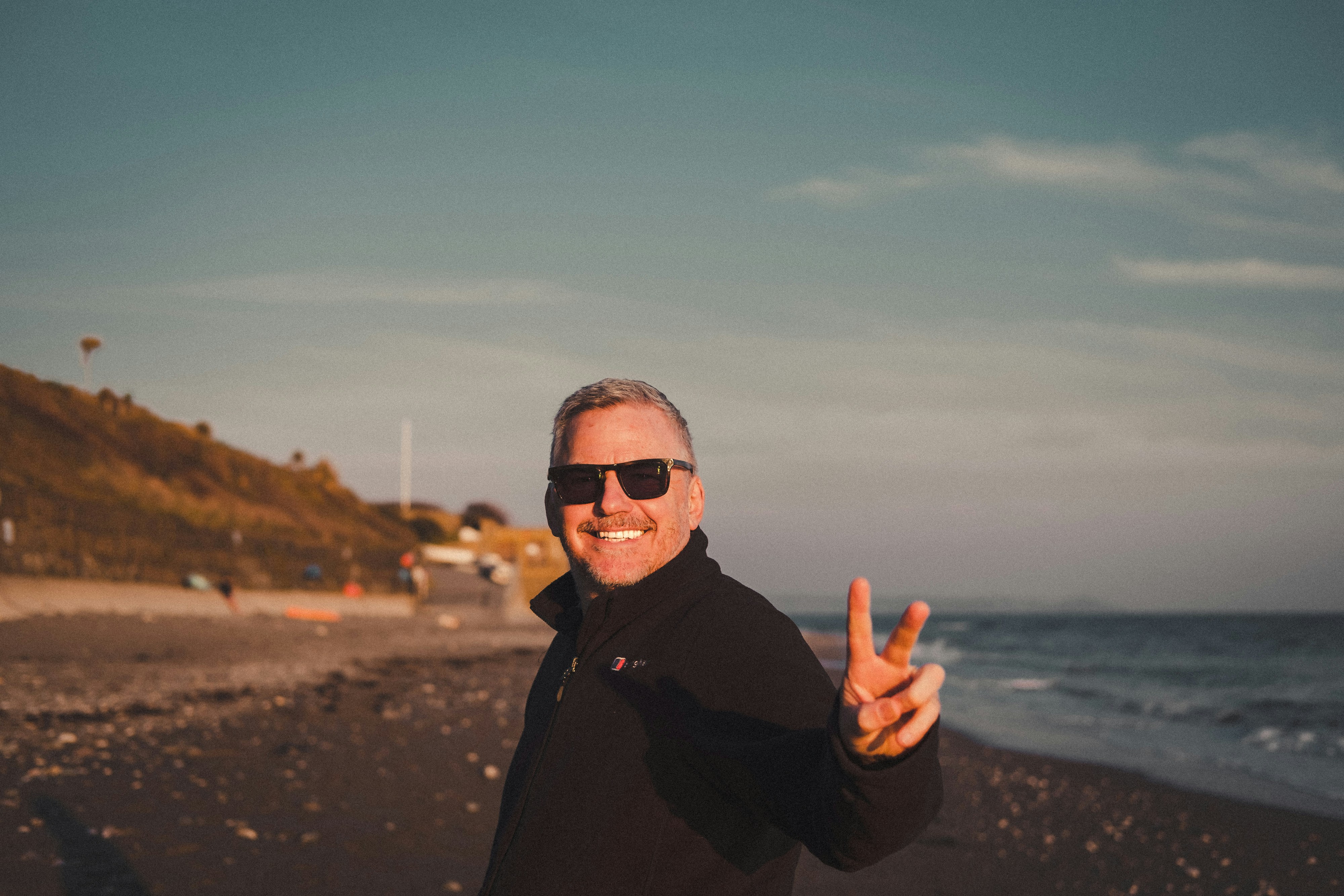 Smiling badge of sunlit confidence on a breezy beach