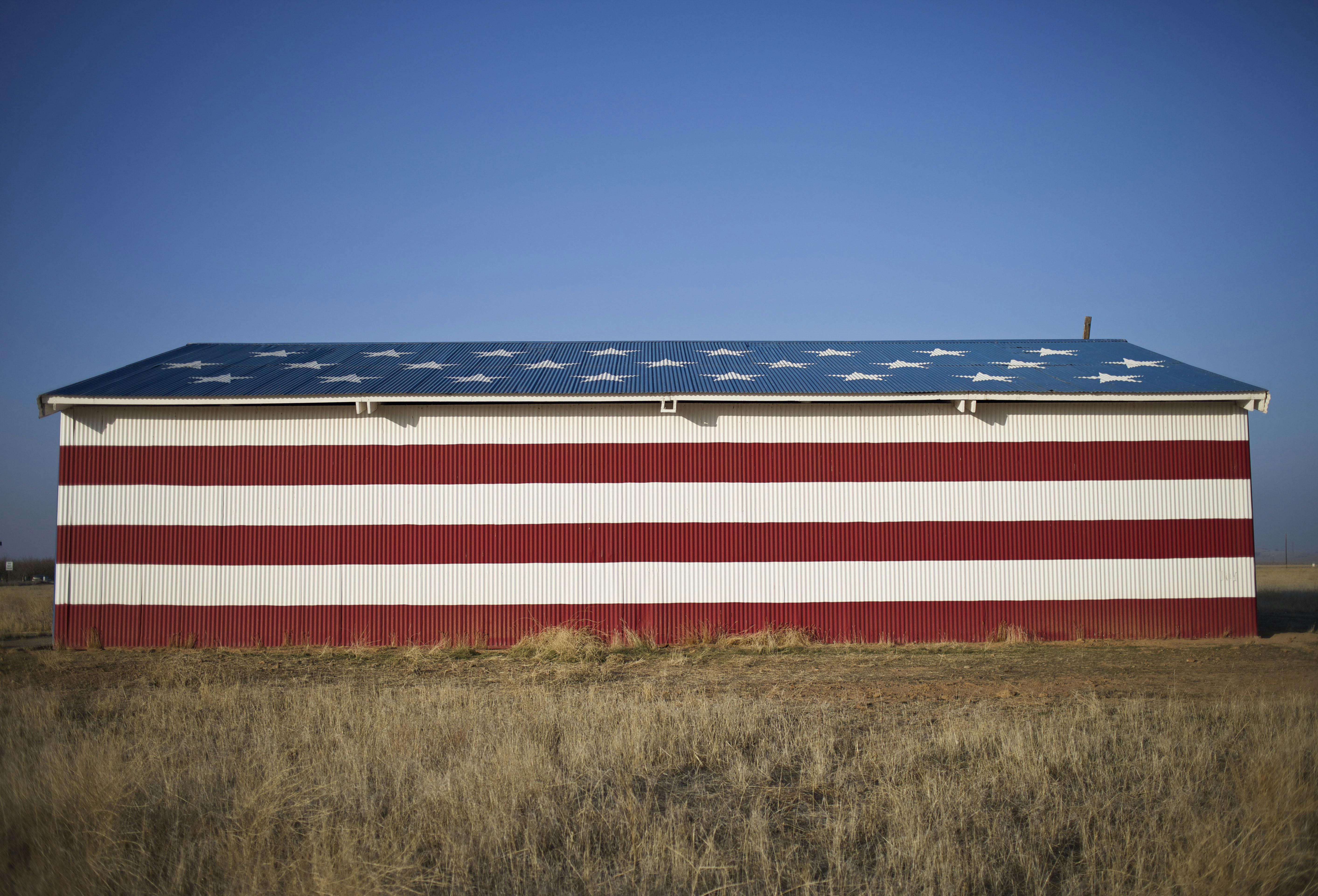 Red-White-Blue Barn on a Quiet Prairie Under a Pristine Blue Sky