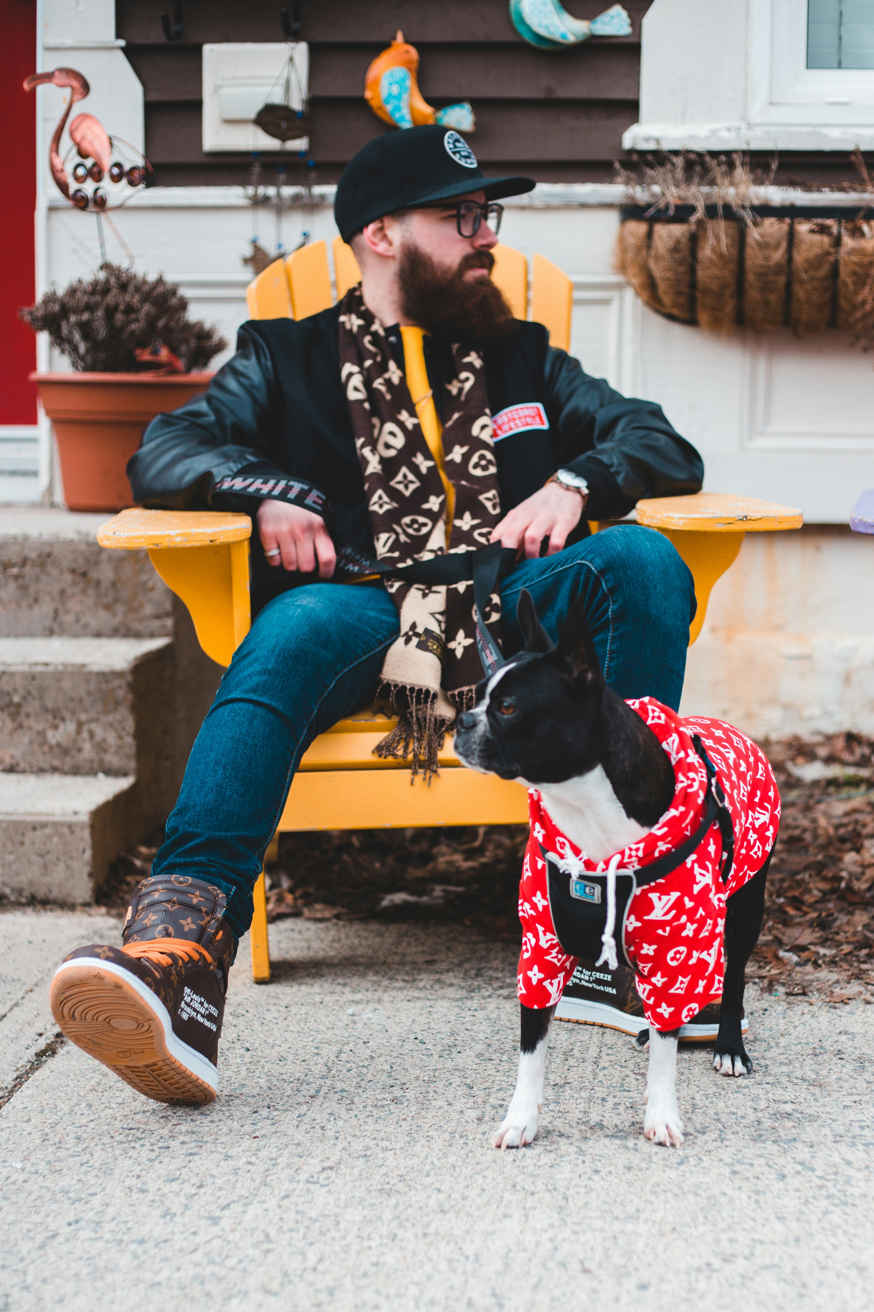 A Quiet Moment on the Porch: Man in Cap with a Dog in Patterned Hoodie