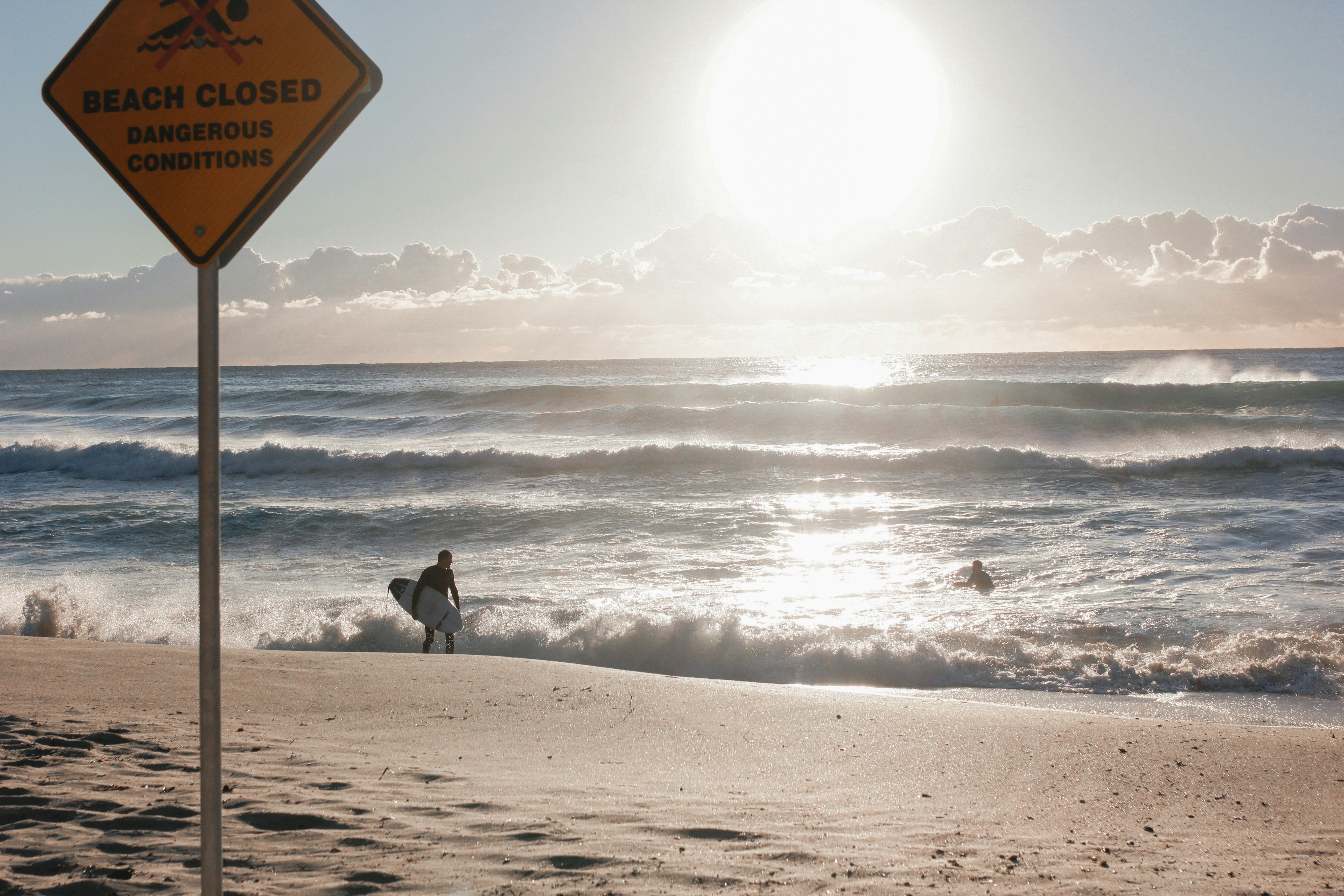 Dawn at a Closed Beach: Signpost, Surfer, and the Golden Sea