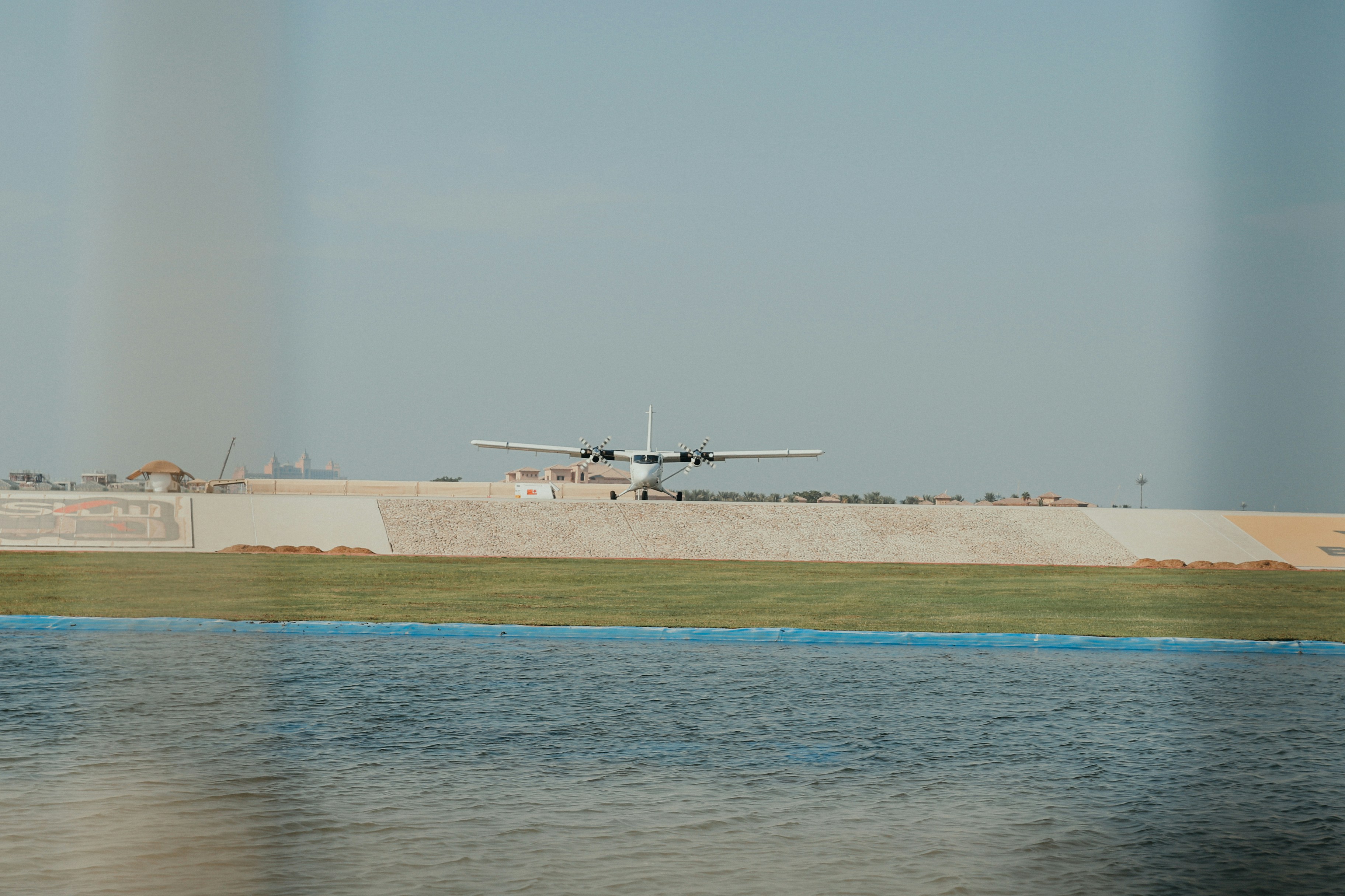 Aerodrome with small white airplane on the horizon