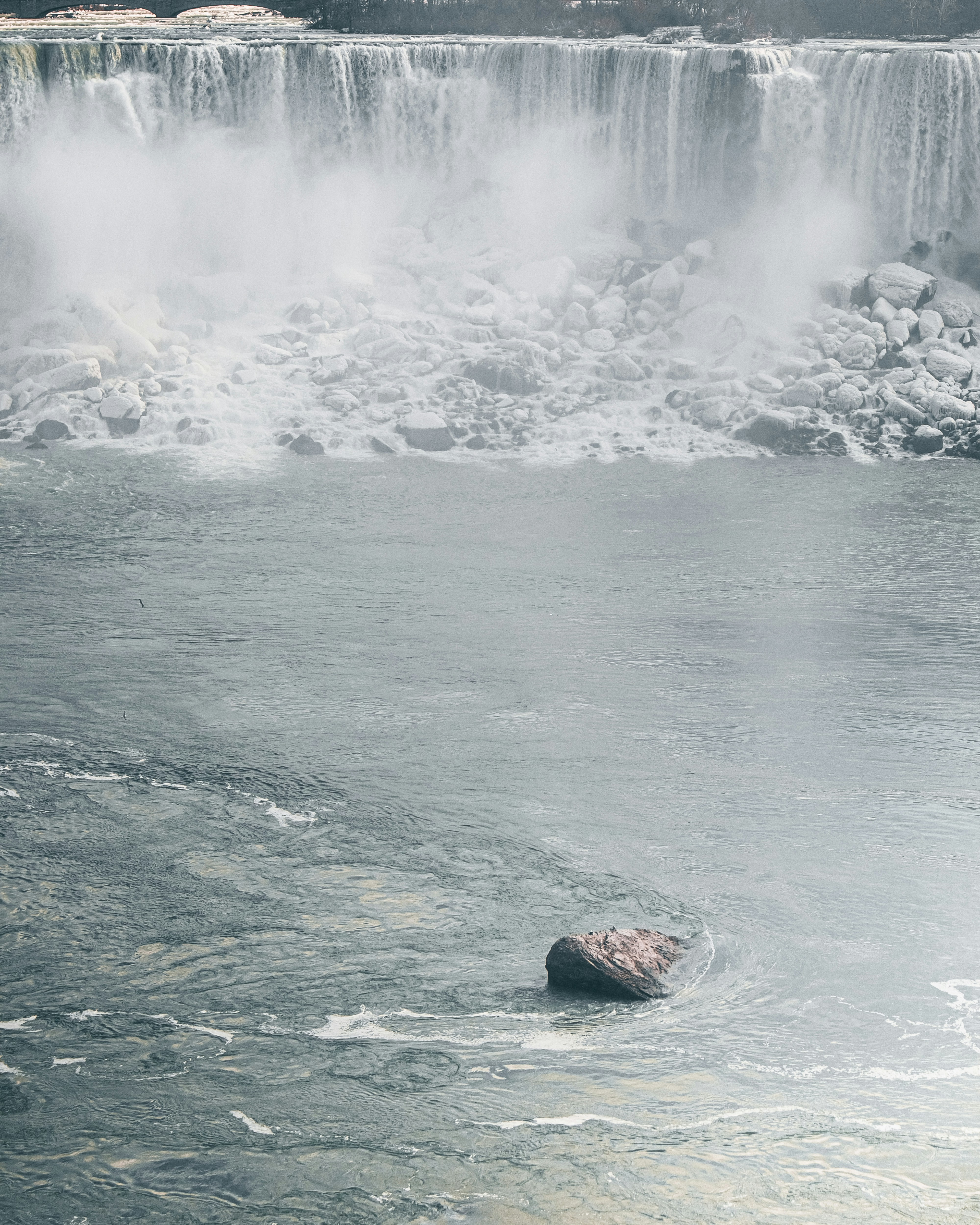 Rising Mist over a Lone Boulder in Turquoise Rapids