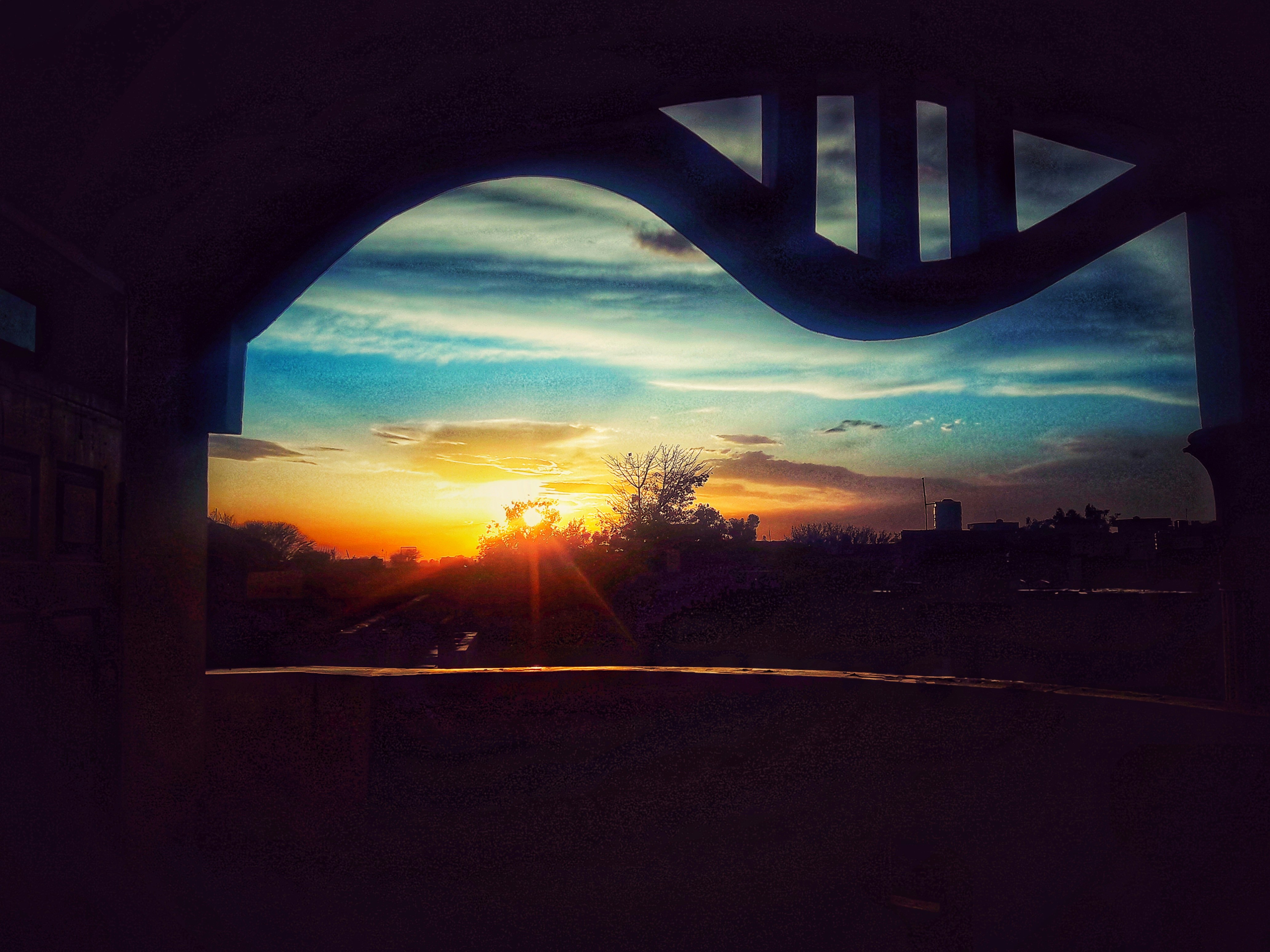 Sunburst Through a Concrete Arch: Dusk Over Silhouettes