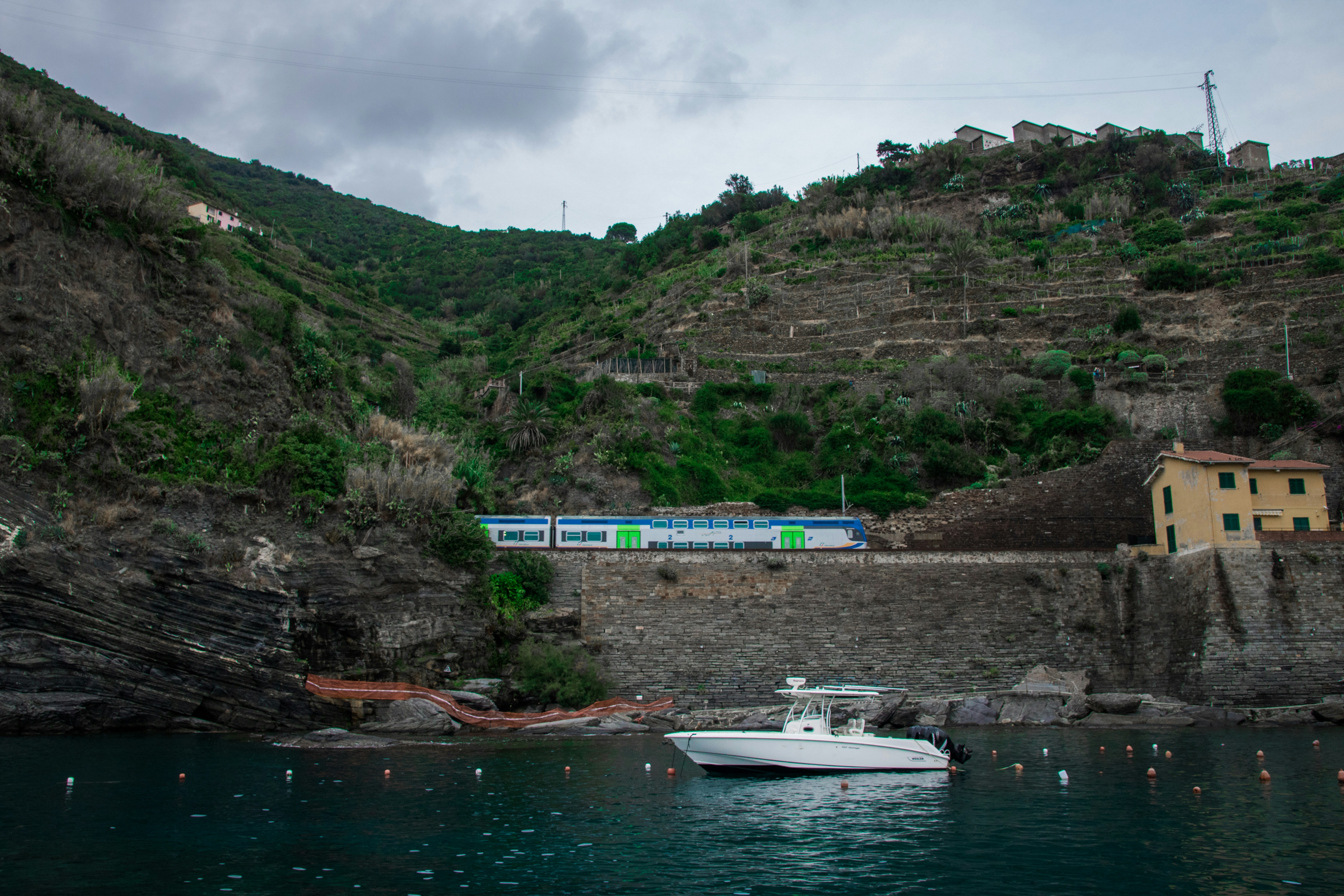 Terraced Hills, Seaside Train, and a White Boat: Harbor Quietude