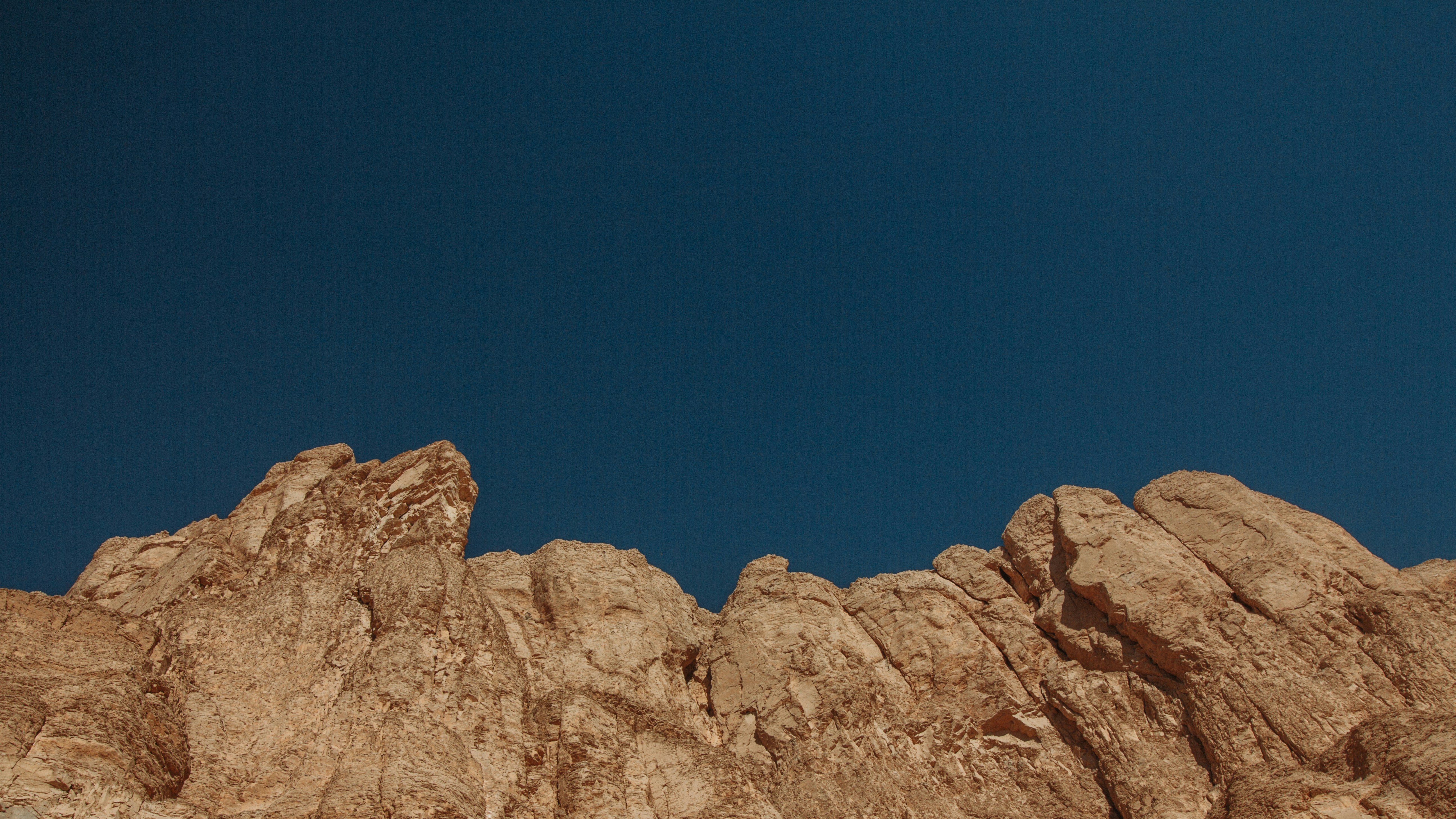 Jagged sandstone formations rise against a deep blue night sky.
