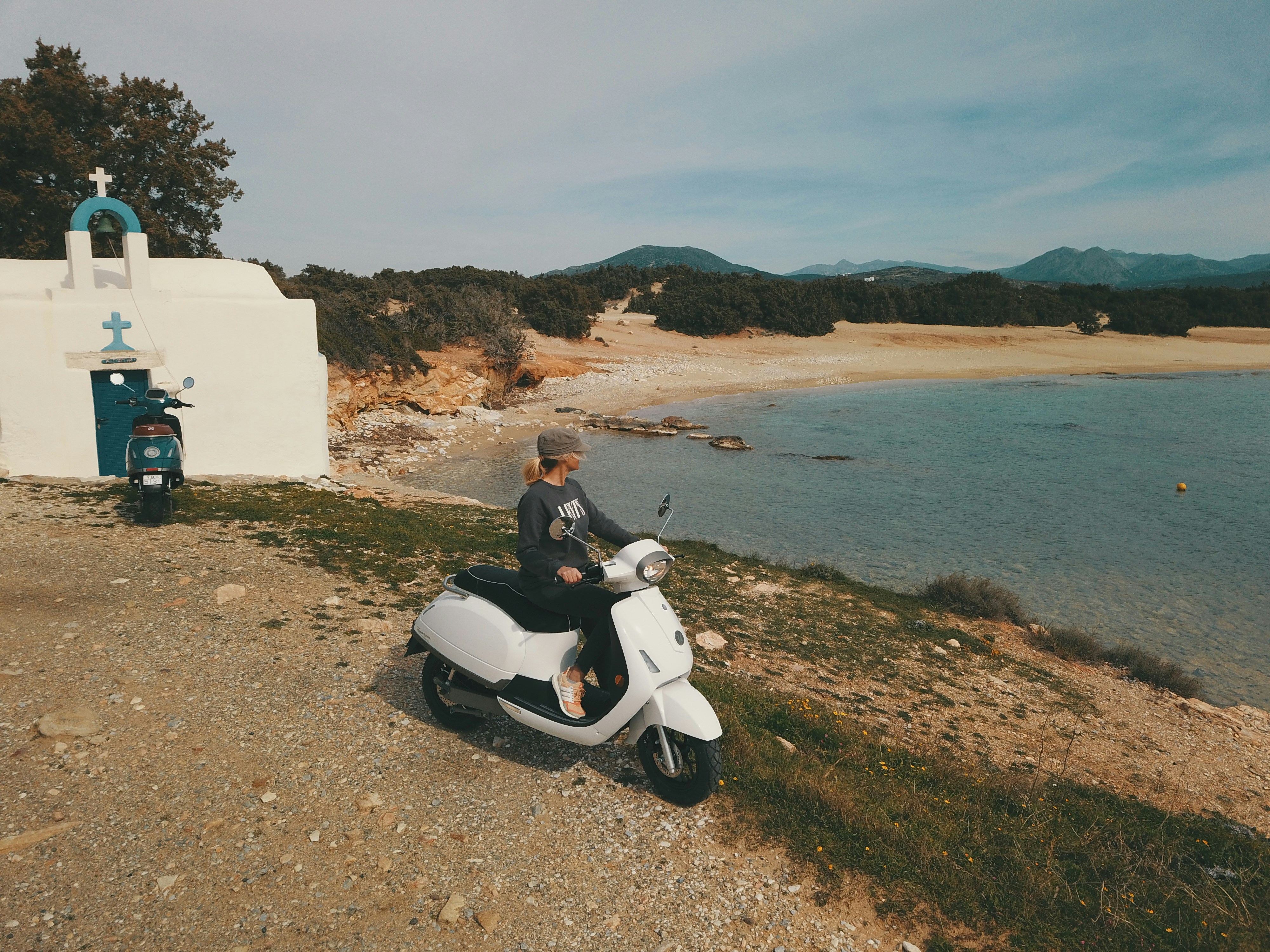 Vespa Pause by a Seaside Chapel on Aegean Cliffs