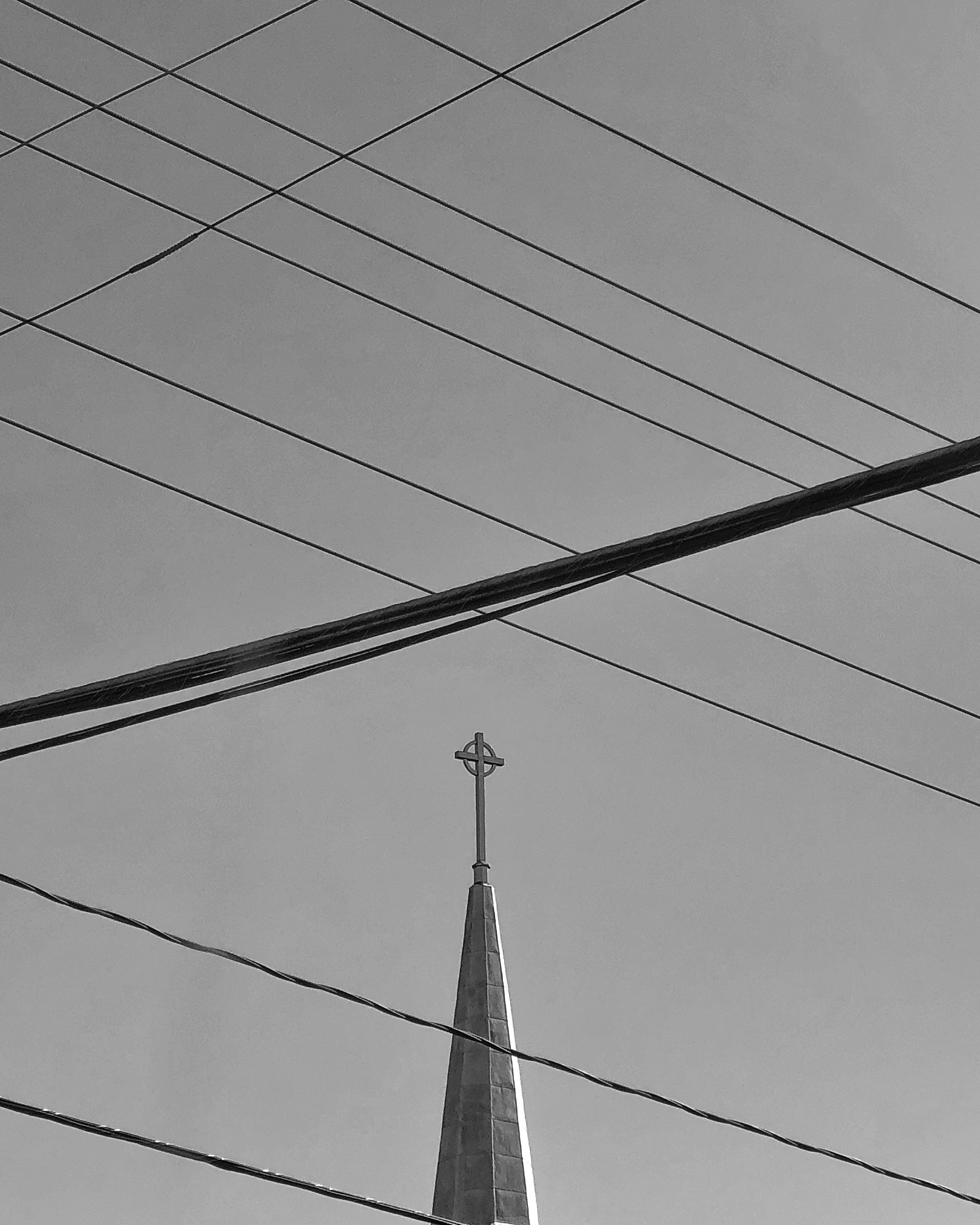 Monochrome Convergence: Steeple Framed by a Web of Wires
