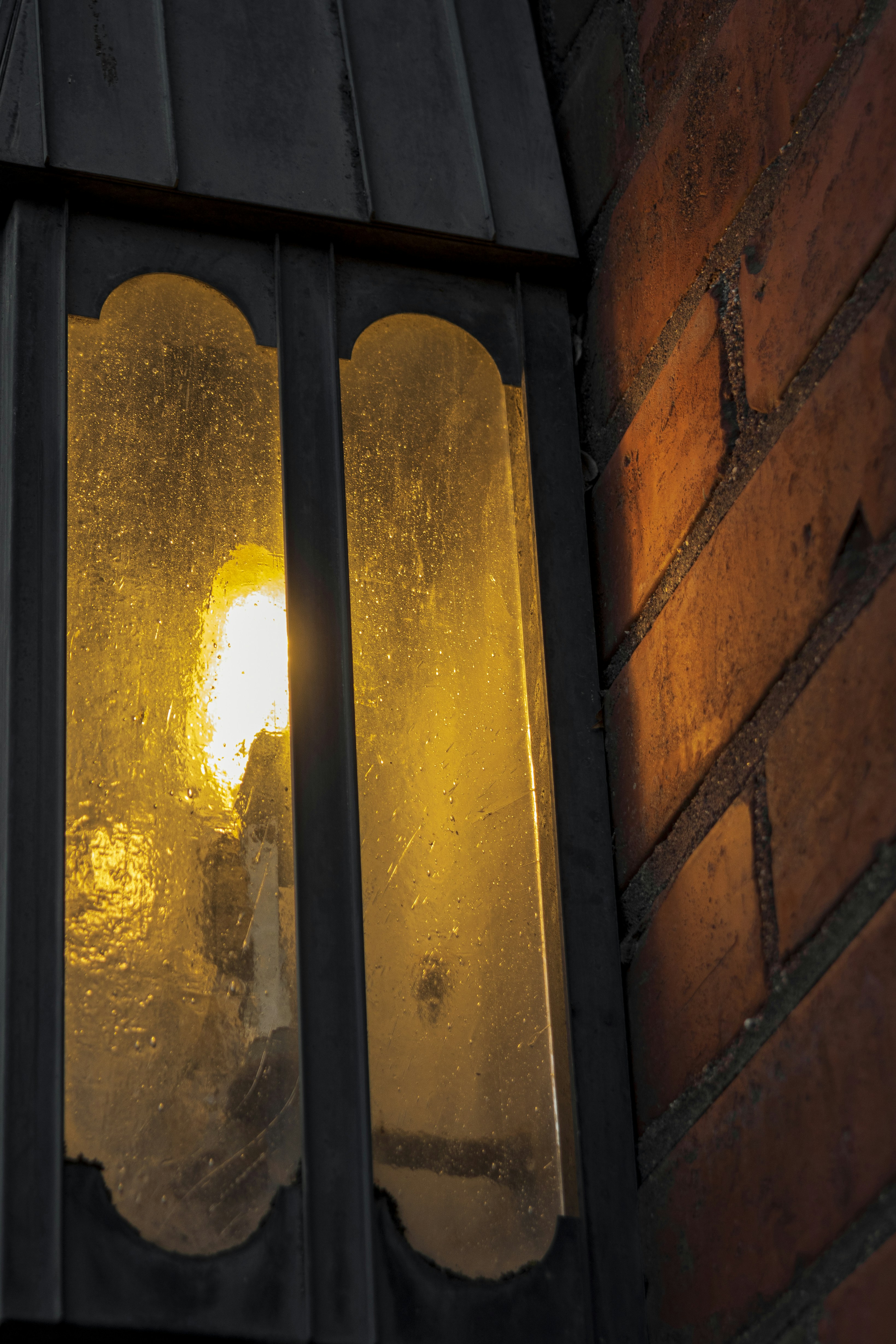 Twin Amber Lanterns Punctuate a Weathered Brick Wall