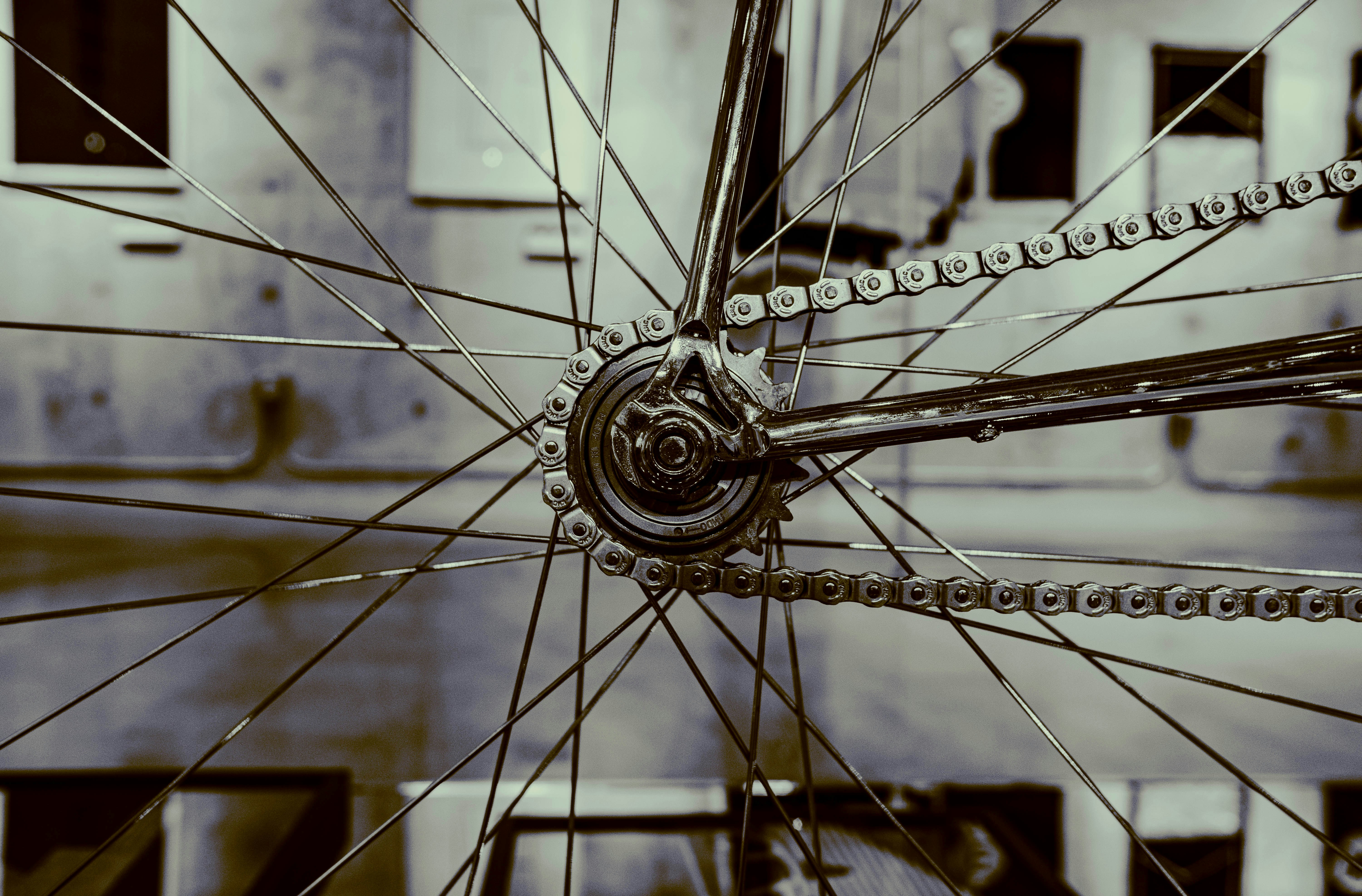 Close-up of a bicycle's chain and gears, showcasing intricate details of mechanical engineering. The image highlights the connection between motion and design.