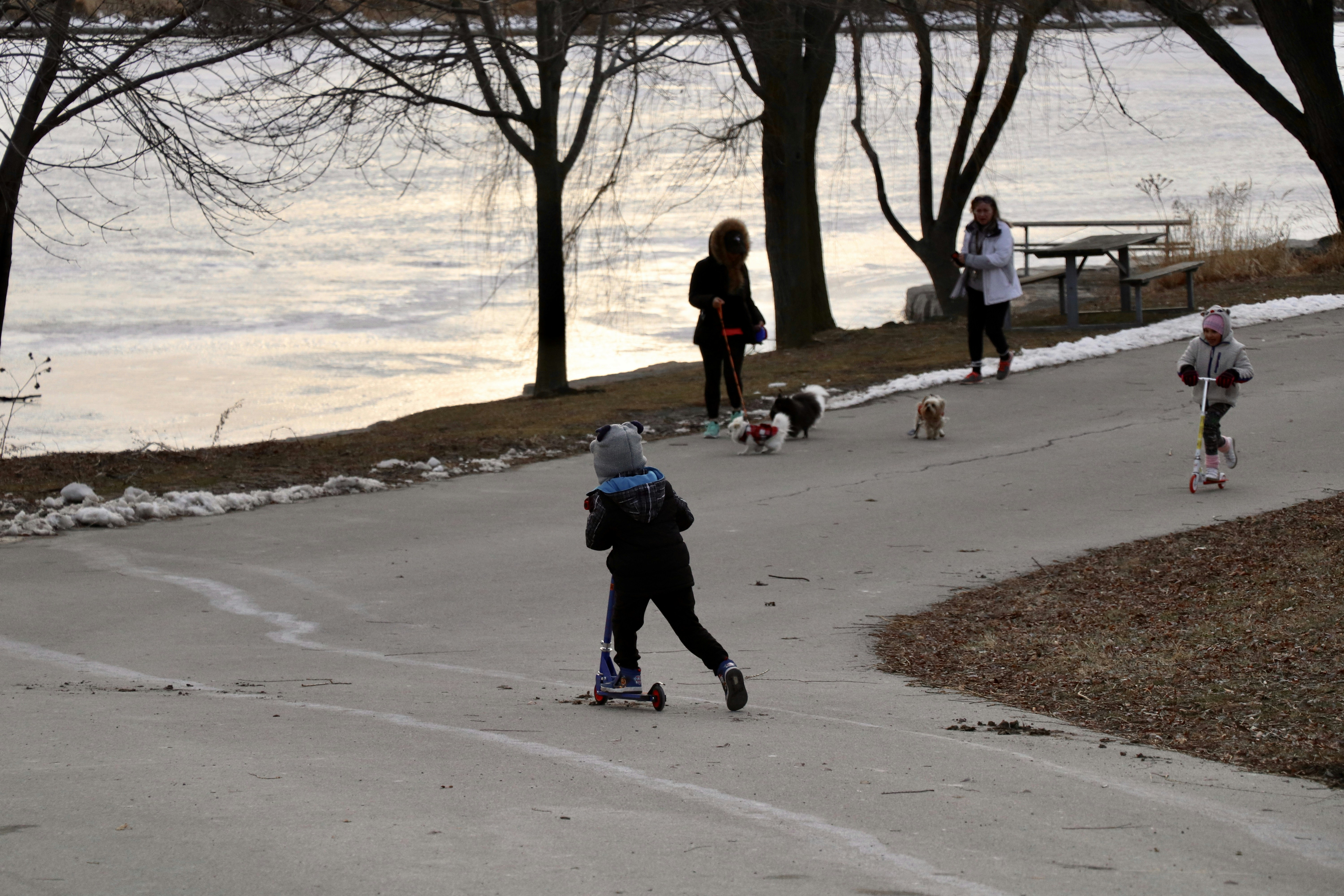Scooter Sprint Along a Snow-Misted Lakeside Promenade