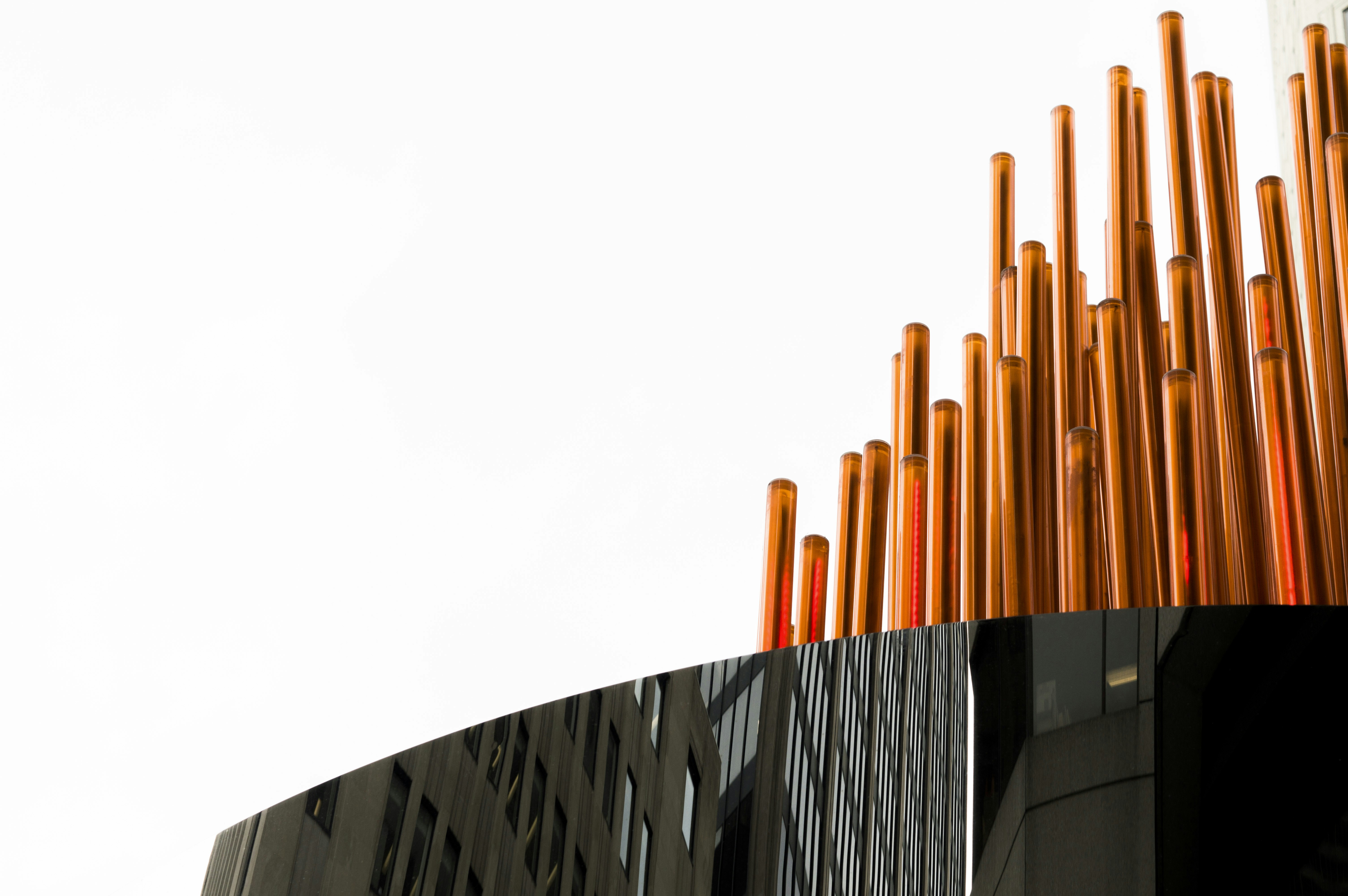 Copper Crown Rising from a Curved Glass Facade
