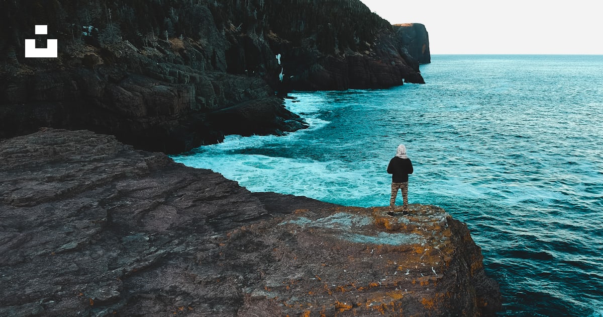 Woman In Black Bikini Standing On Rock Formation Near Sea During