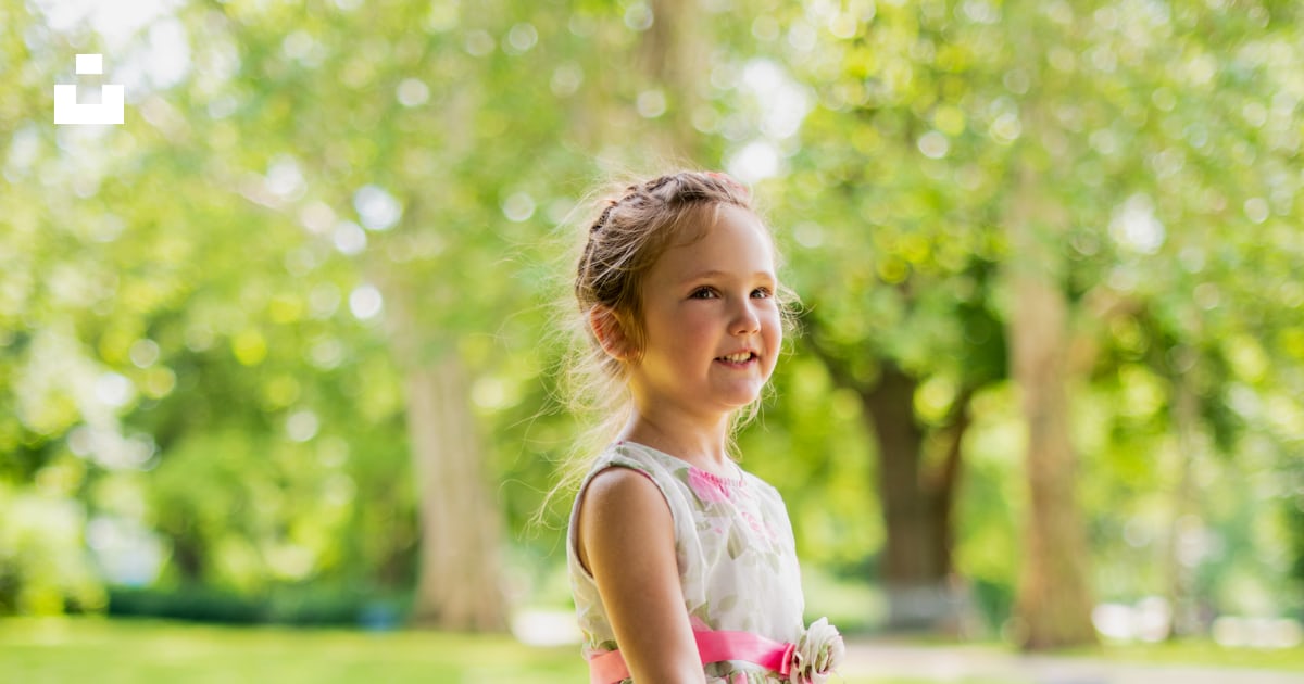 昼間、緑の芝生の上に立つピンクと白の花柄のドレスを着た女の子の写真 UnsplashのГерманияの無料画像
