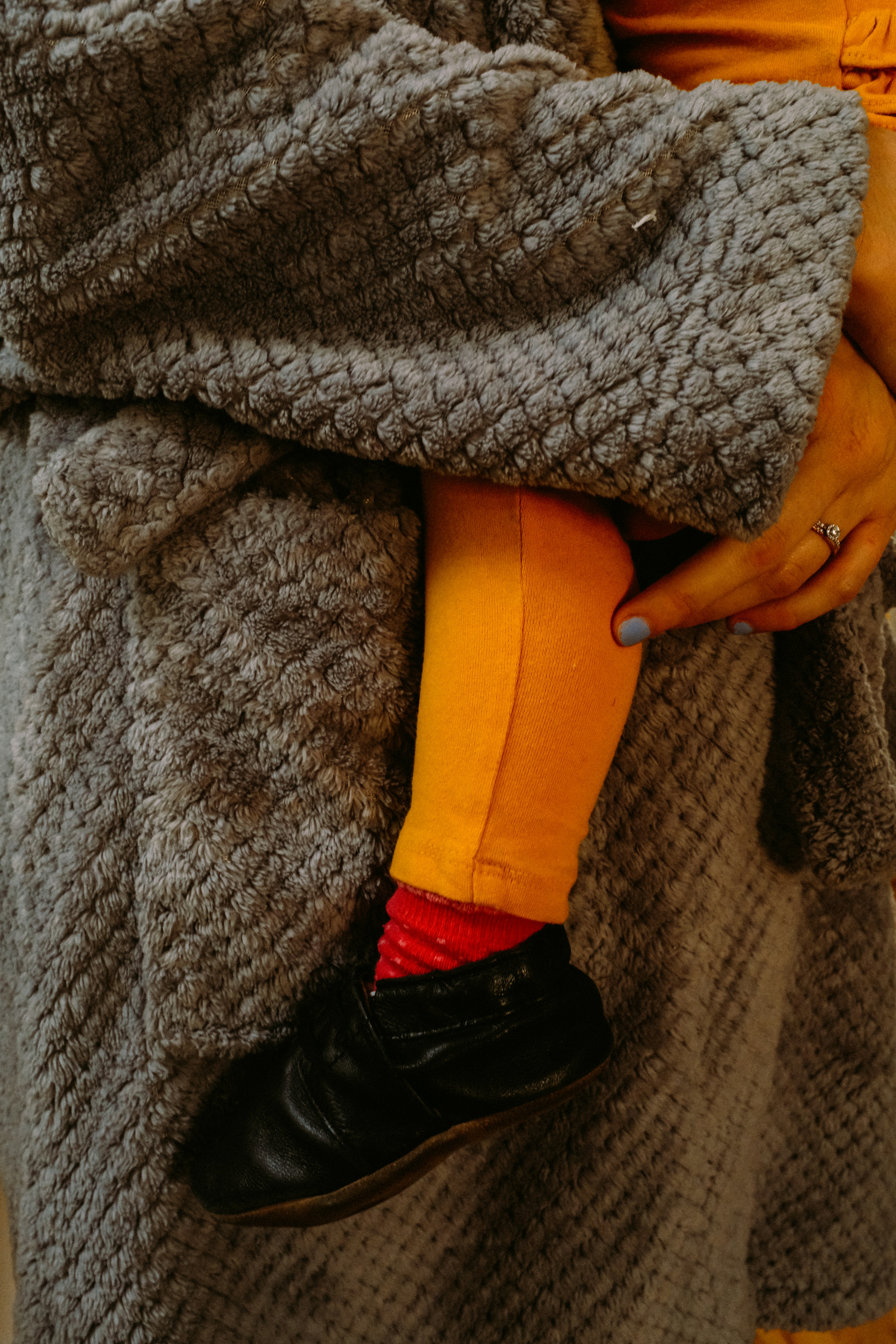 Cozy Layers: A Child's Leg Nestled in Warm Gray Fleece