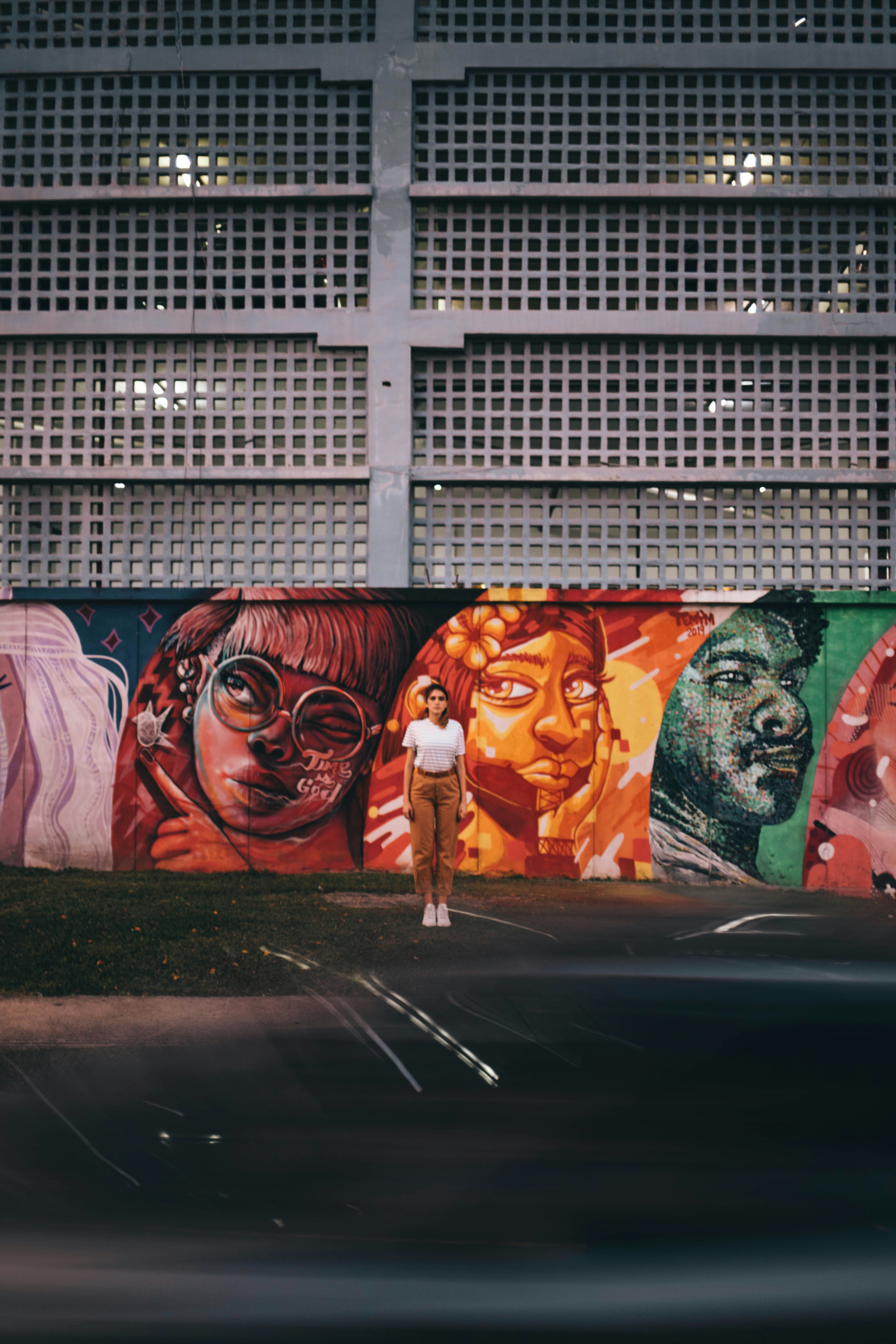 Center Stage in Color: A Quiet Figure Among the Mural Giants