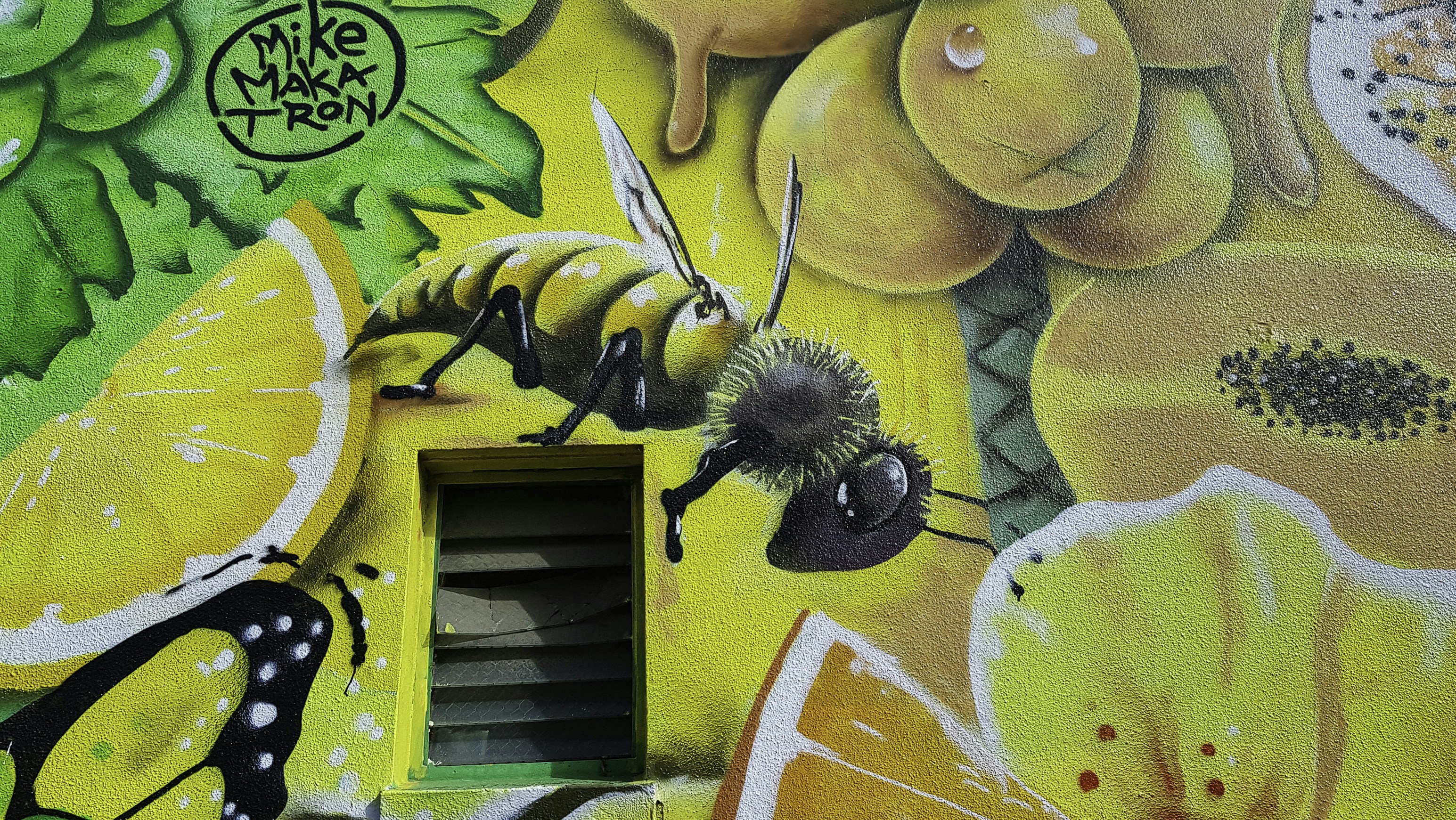 Bee at the Vent: A Citrus Graffiti Portrait on a Lemon Wall