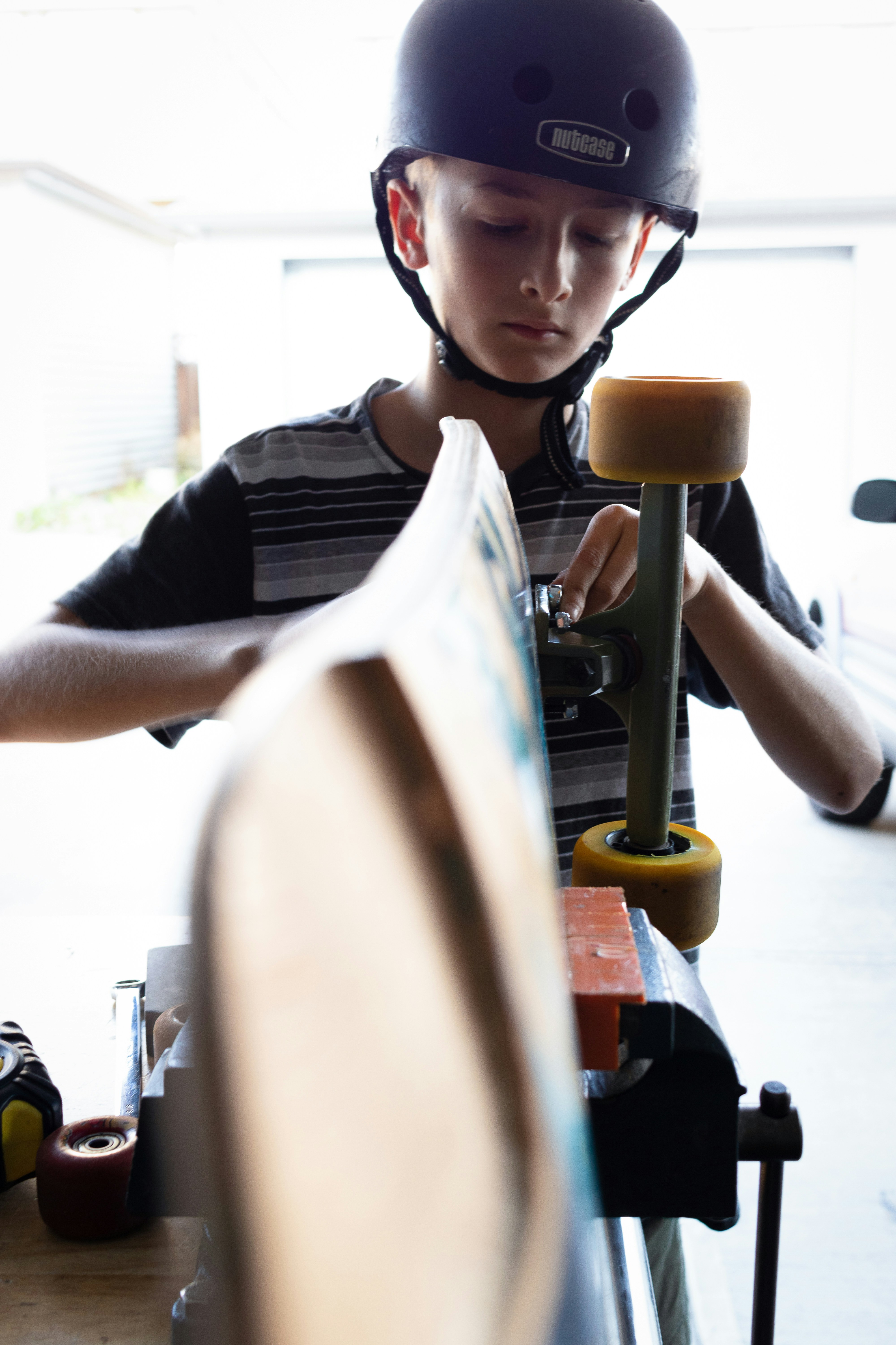 boy fixing skateboard with tools