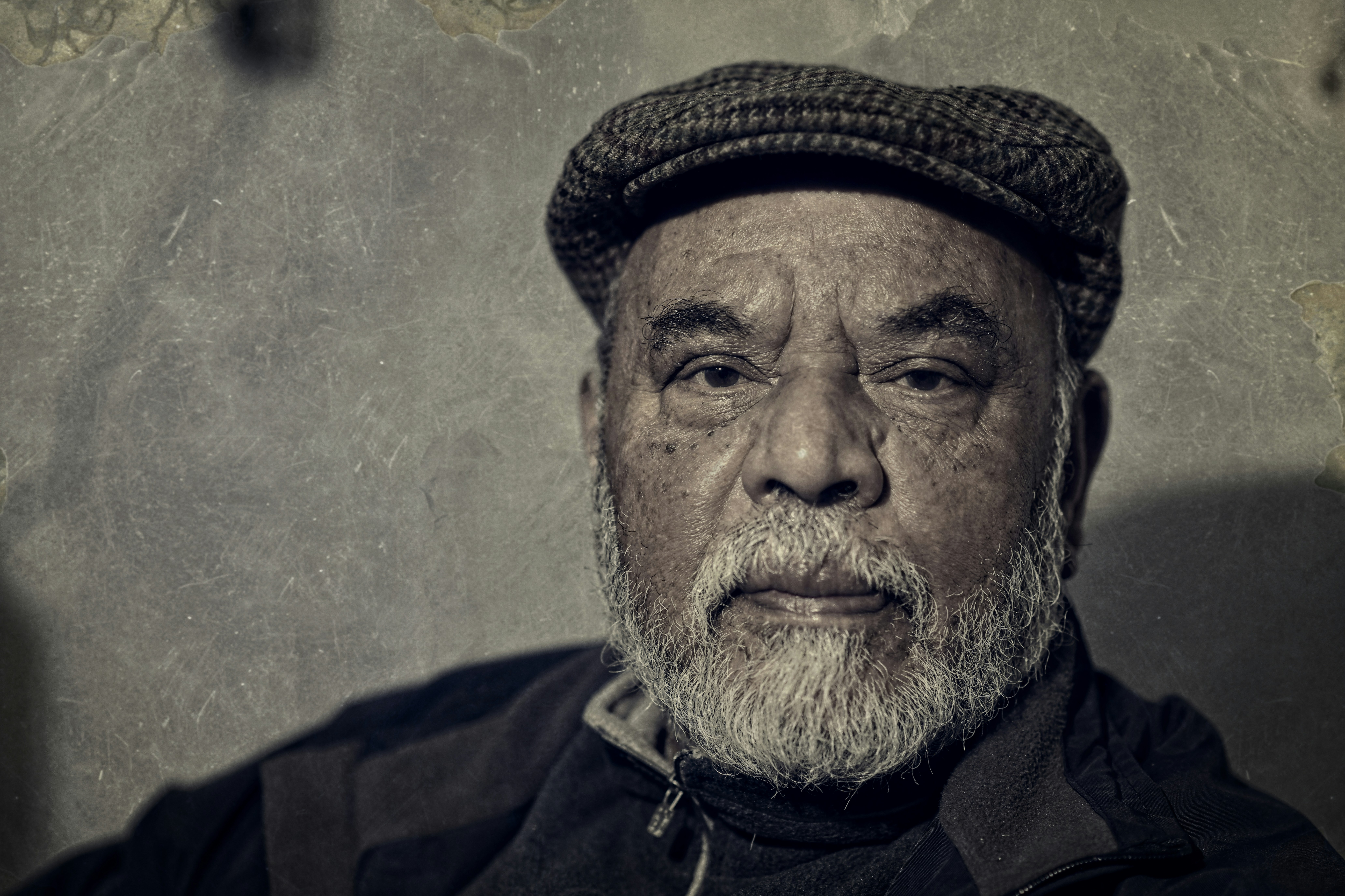 Grit and Gaze: A Monochrome Portrait of a Weathered Elder