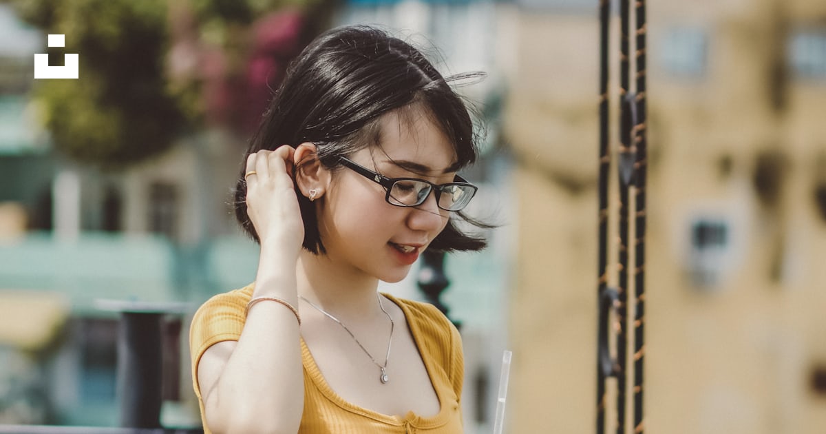 흰색 컵을 들고 검은 선글라스를 착용 한 노란색 탱크 탑을 입은 여자 사진 Unsplash의 무료 의복 이미지