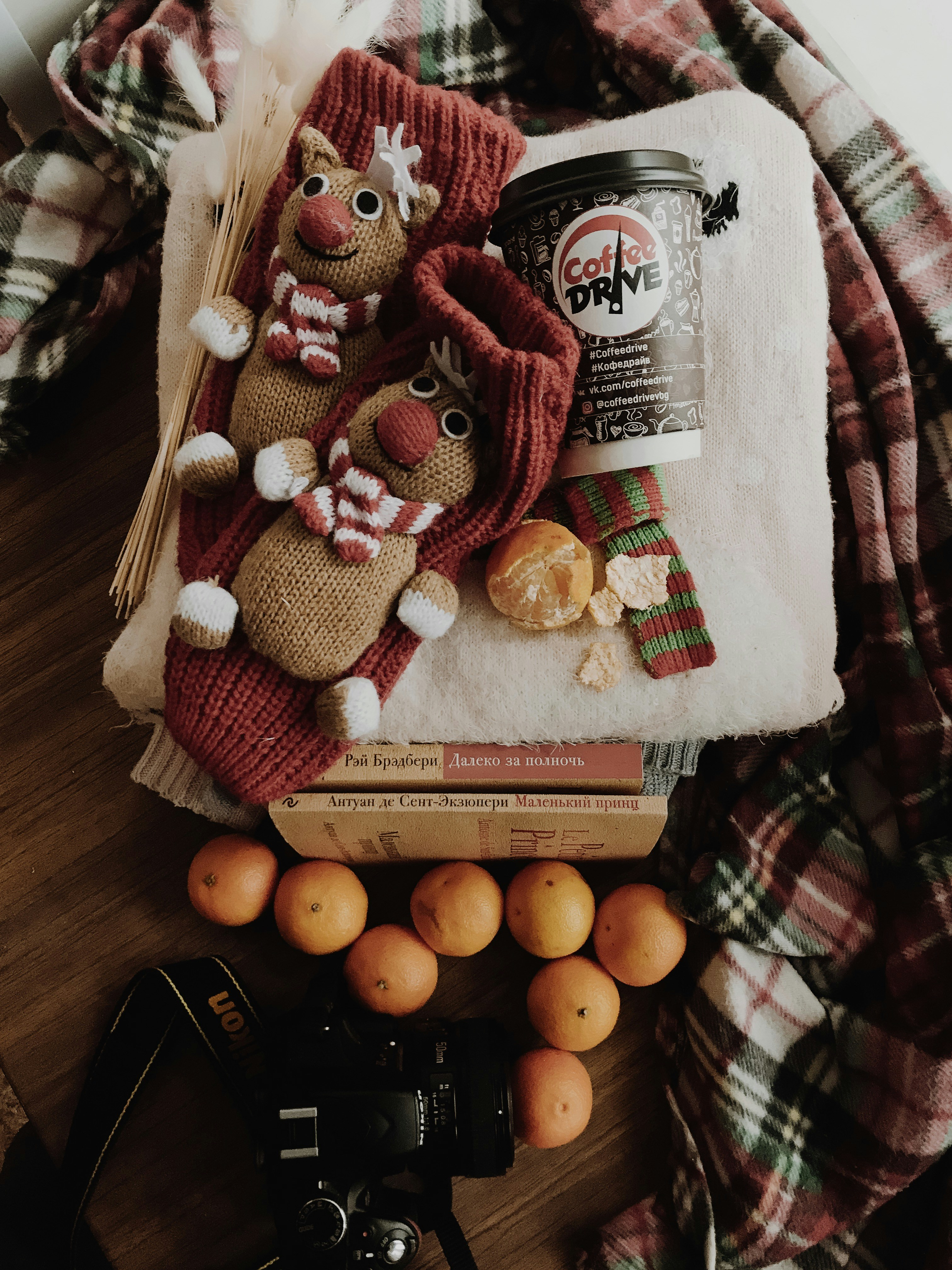 Cozy Contrast: Coffee Cup Among Knitted Reindeer and Tangerines
