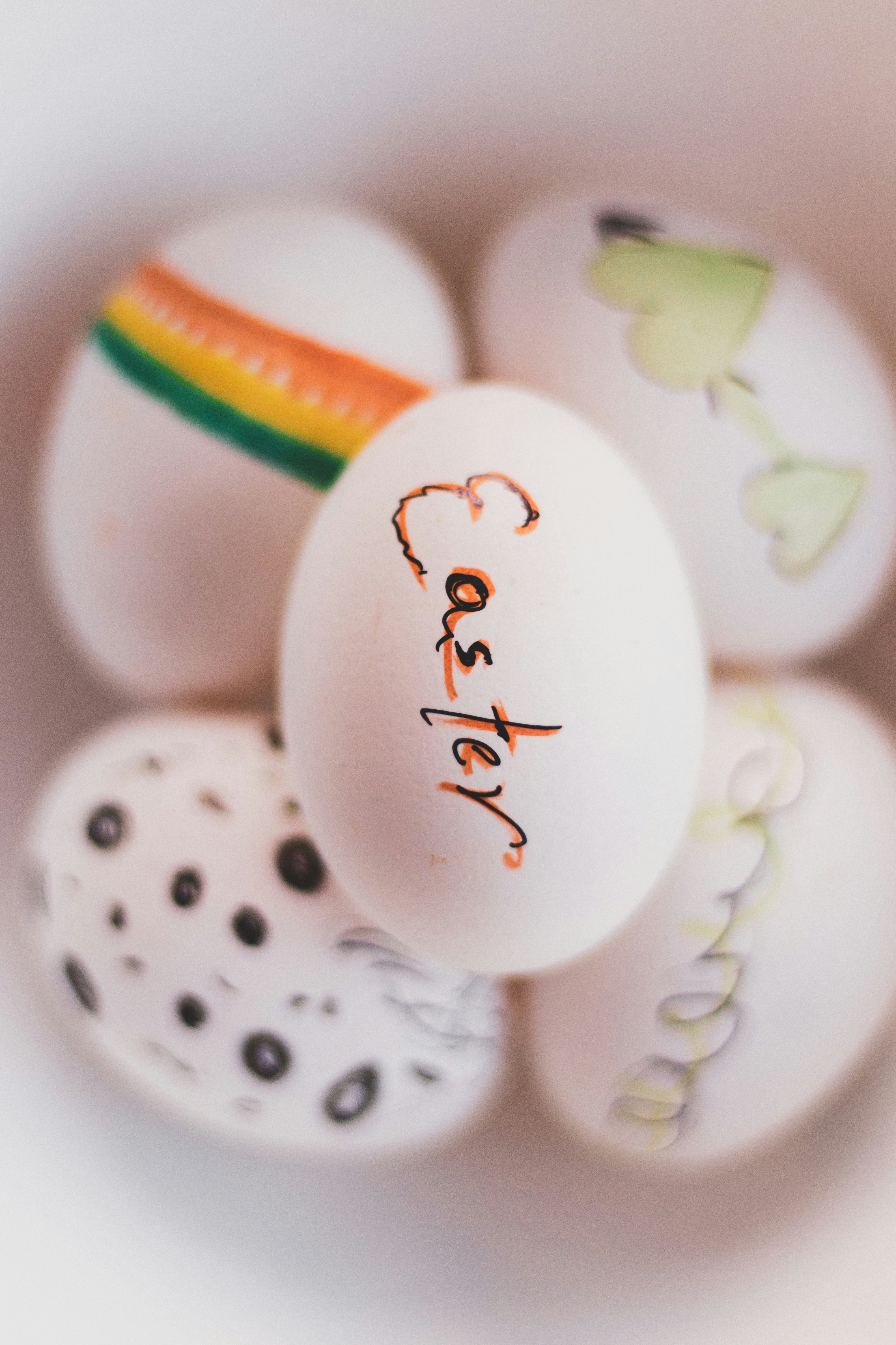 Whispers of Easter: hand-lettered eggs among pastel blooms in soft focus